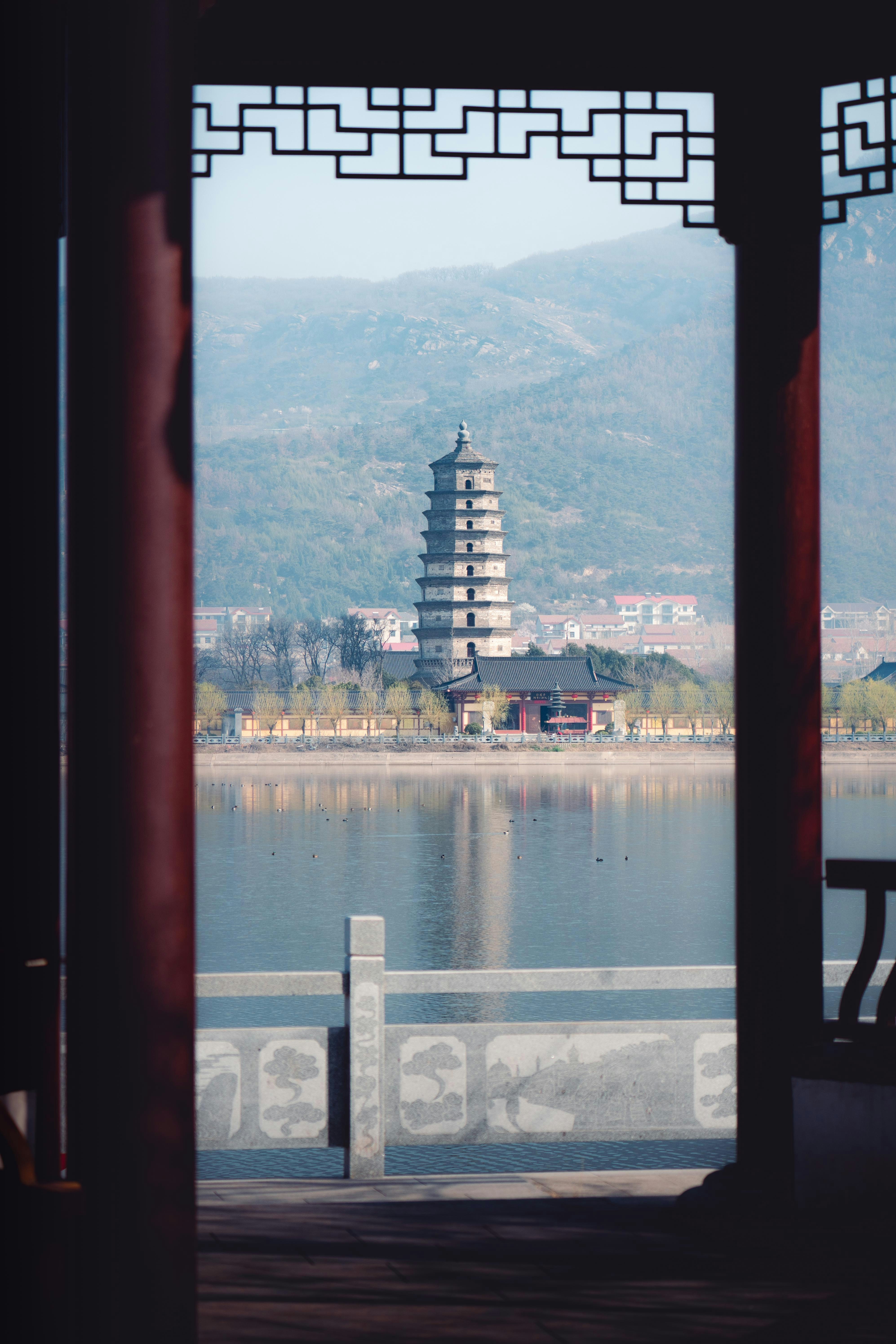 Framed by Lattice: The Central Pagoda Rising Over a Serene Lake