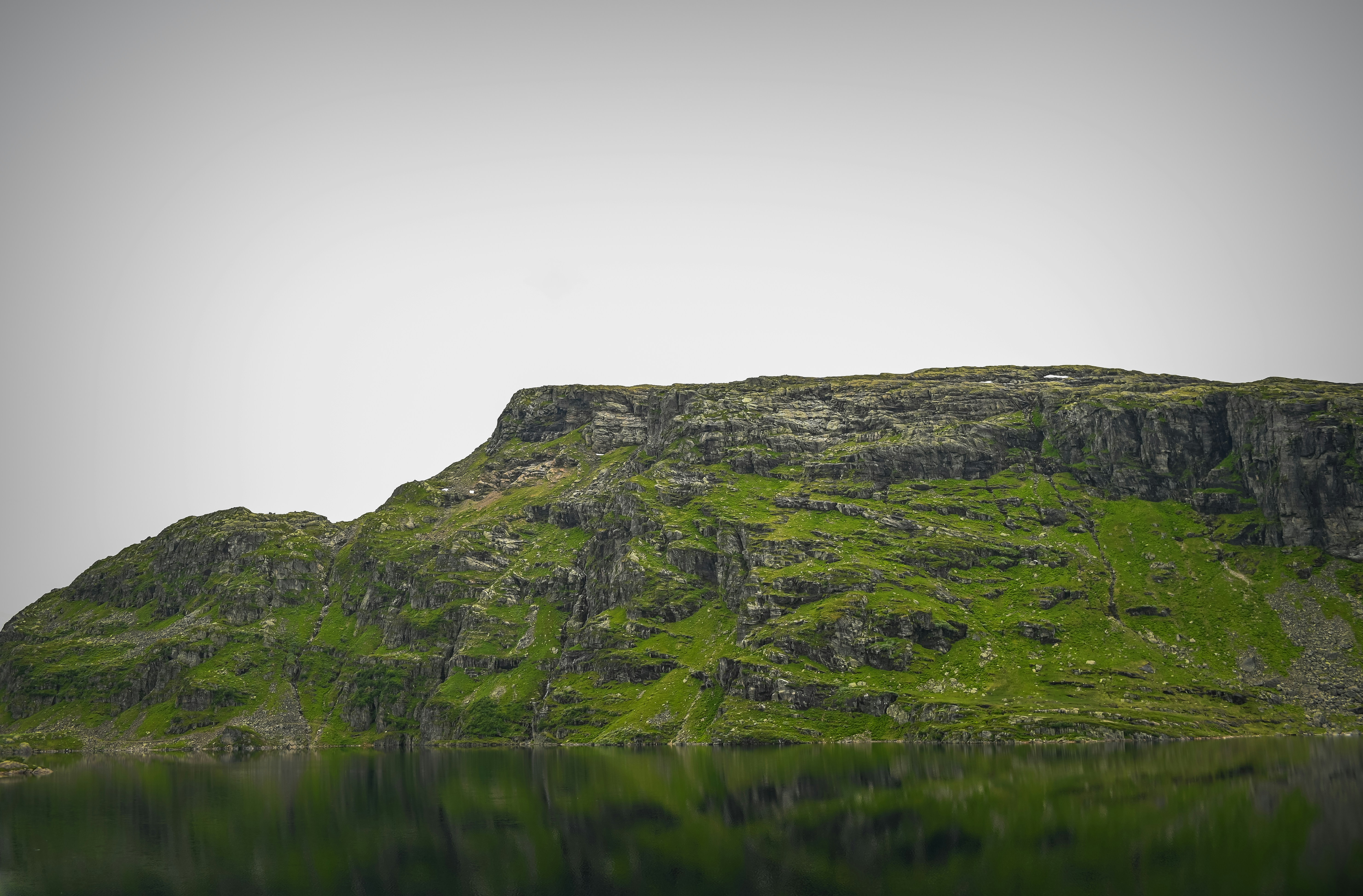 Emerald Cliff Fringed by a Glassy Lake