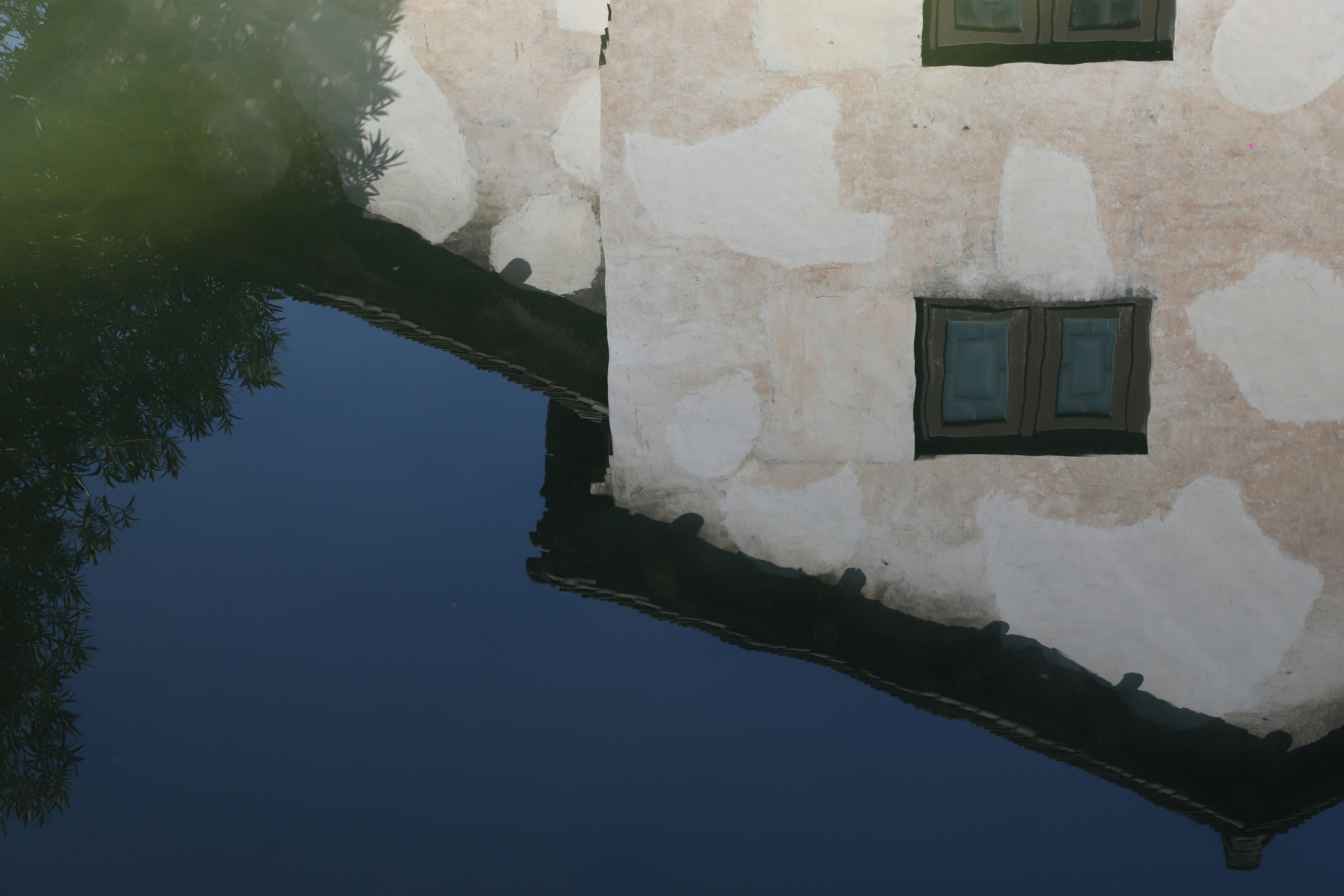 Reflections of a Rustic Facade on Quiet Water