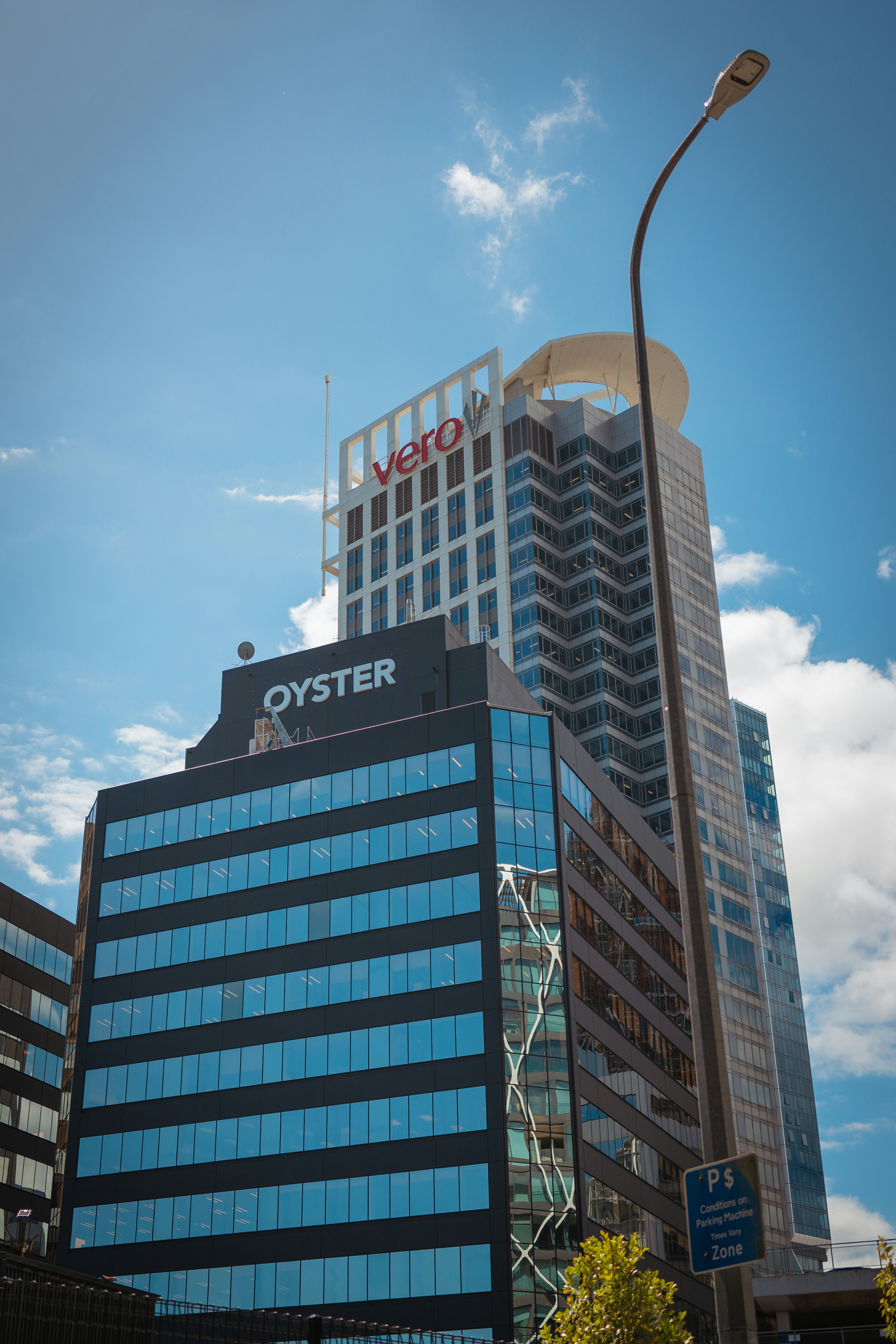 Cobalt Towers Under a Cerulean Sky: A Cityscape of Glass and Signage