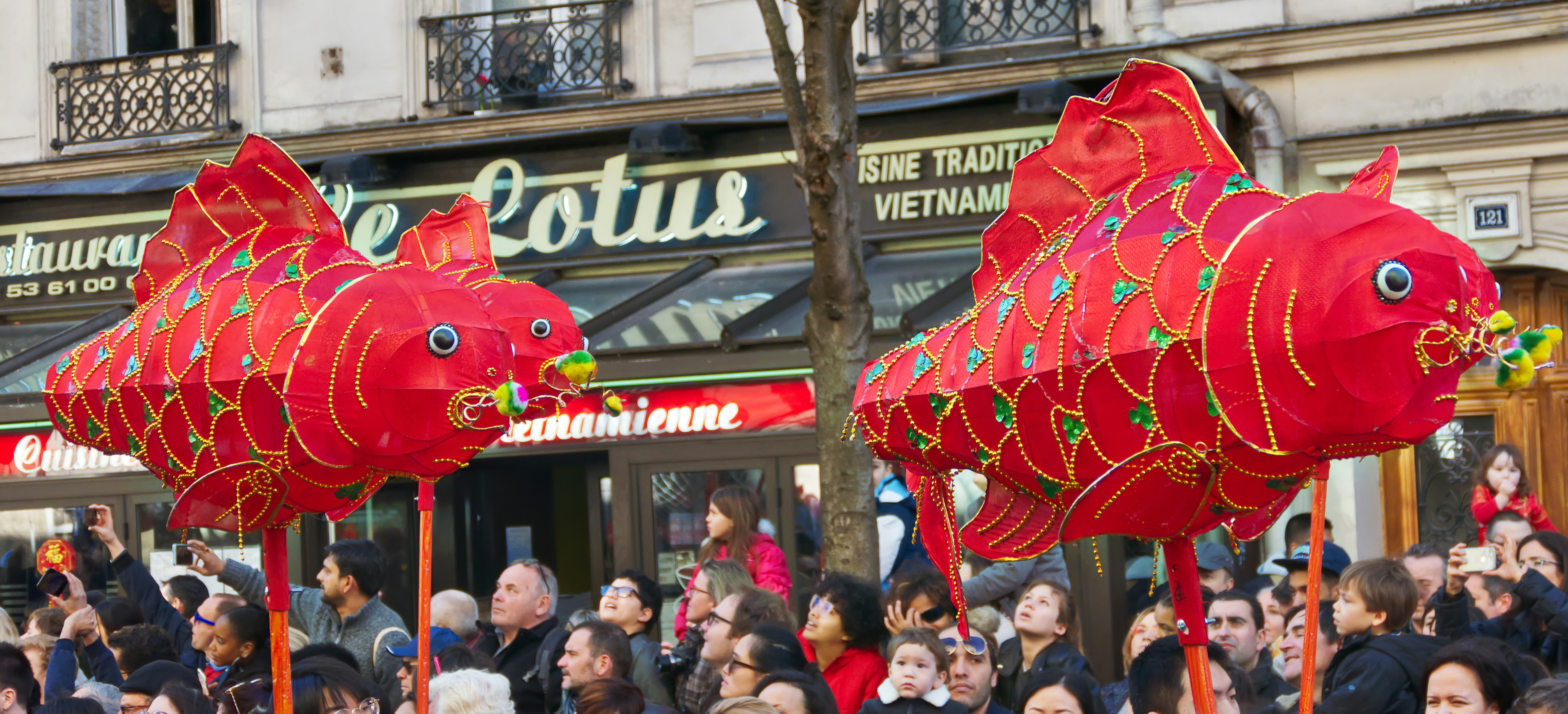 Two Red Koi Lanterns Hover Over a Bustling Street Festival