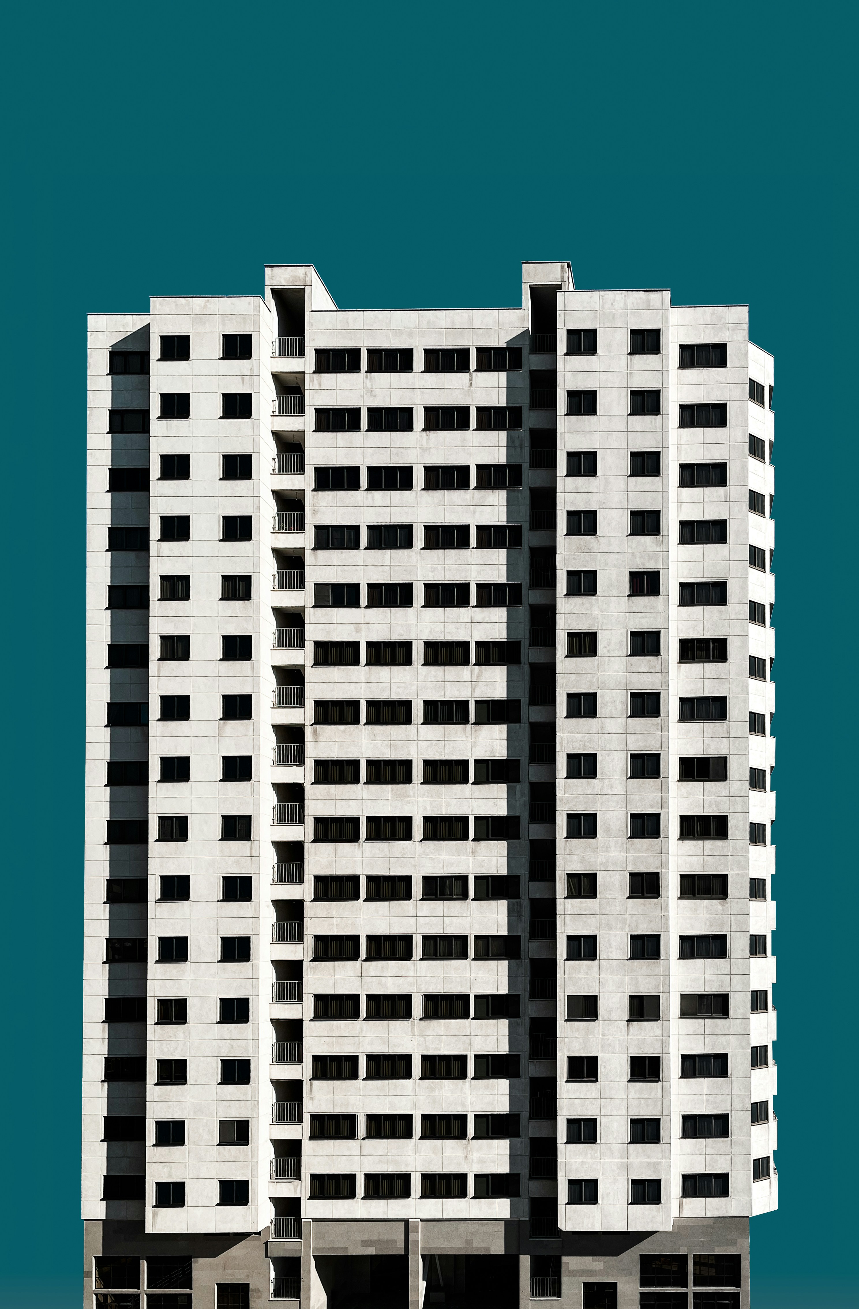 Architectural shot with iPhone 12 Camera. | a tall white building sitting next to a body of water