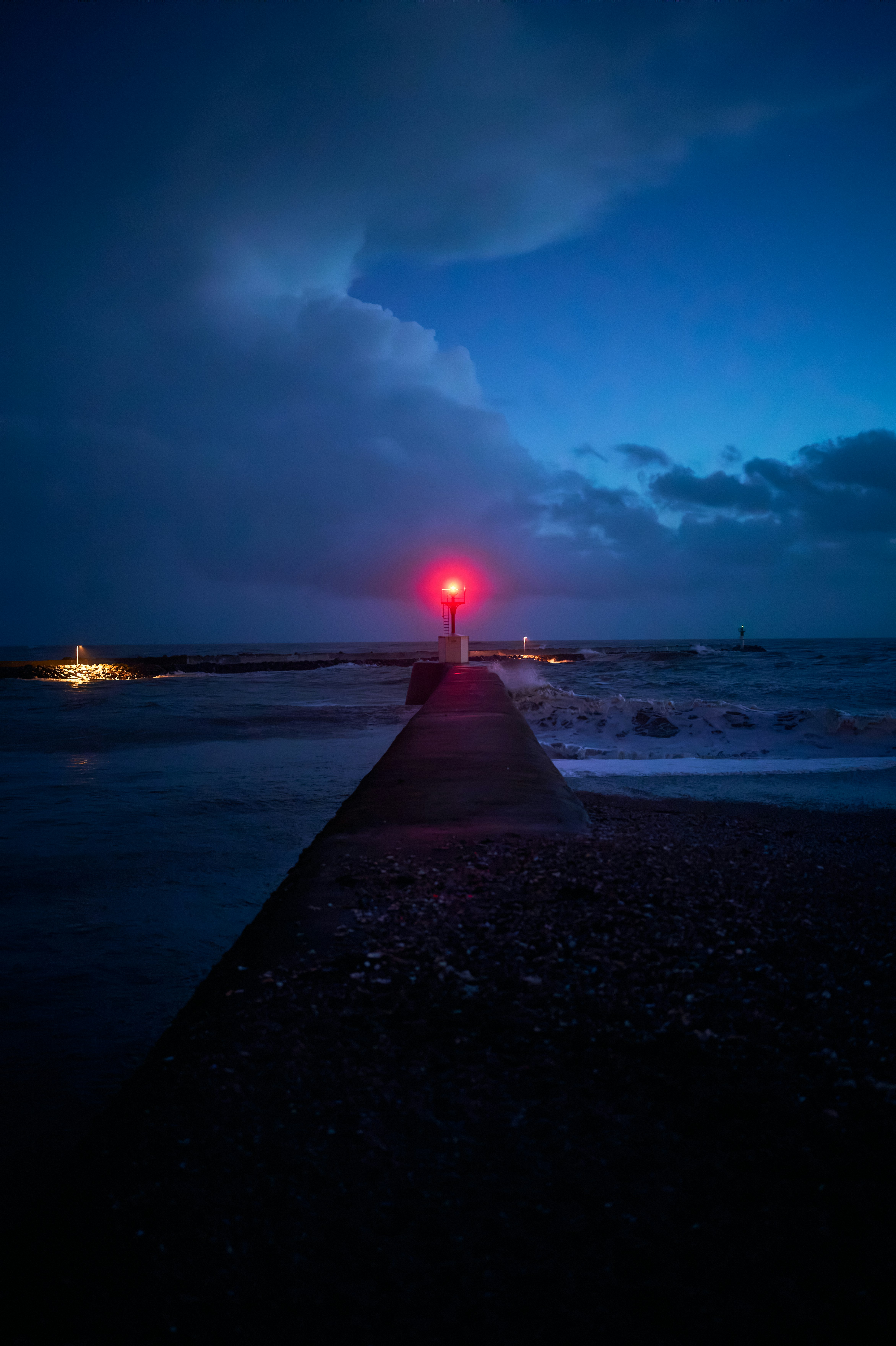 Red Beacon at the End of a Velvet Blue Jetty at Twilight
