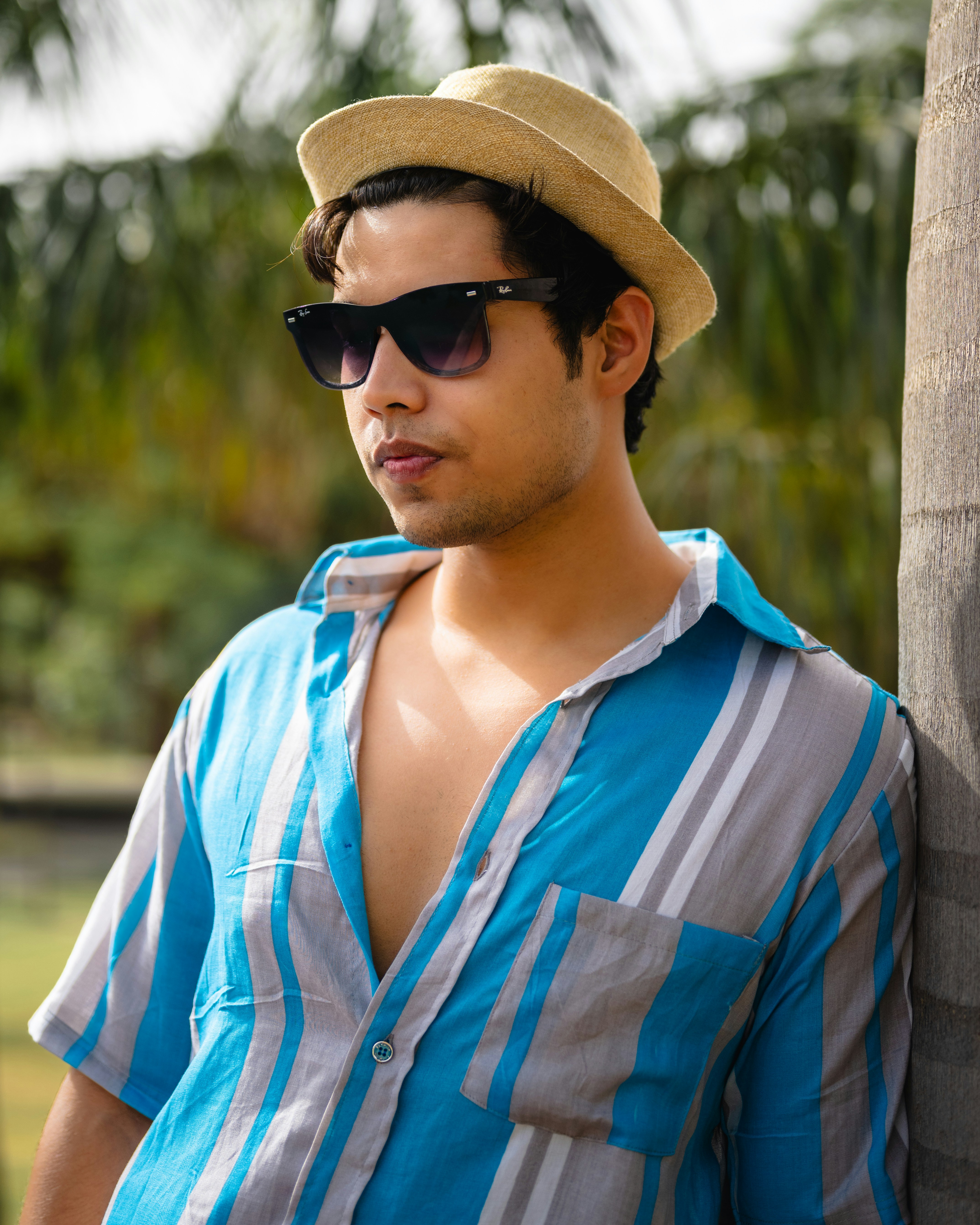 Blue Stripes Under Palm Shade: A Relaxed Outdoor Portrait