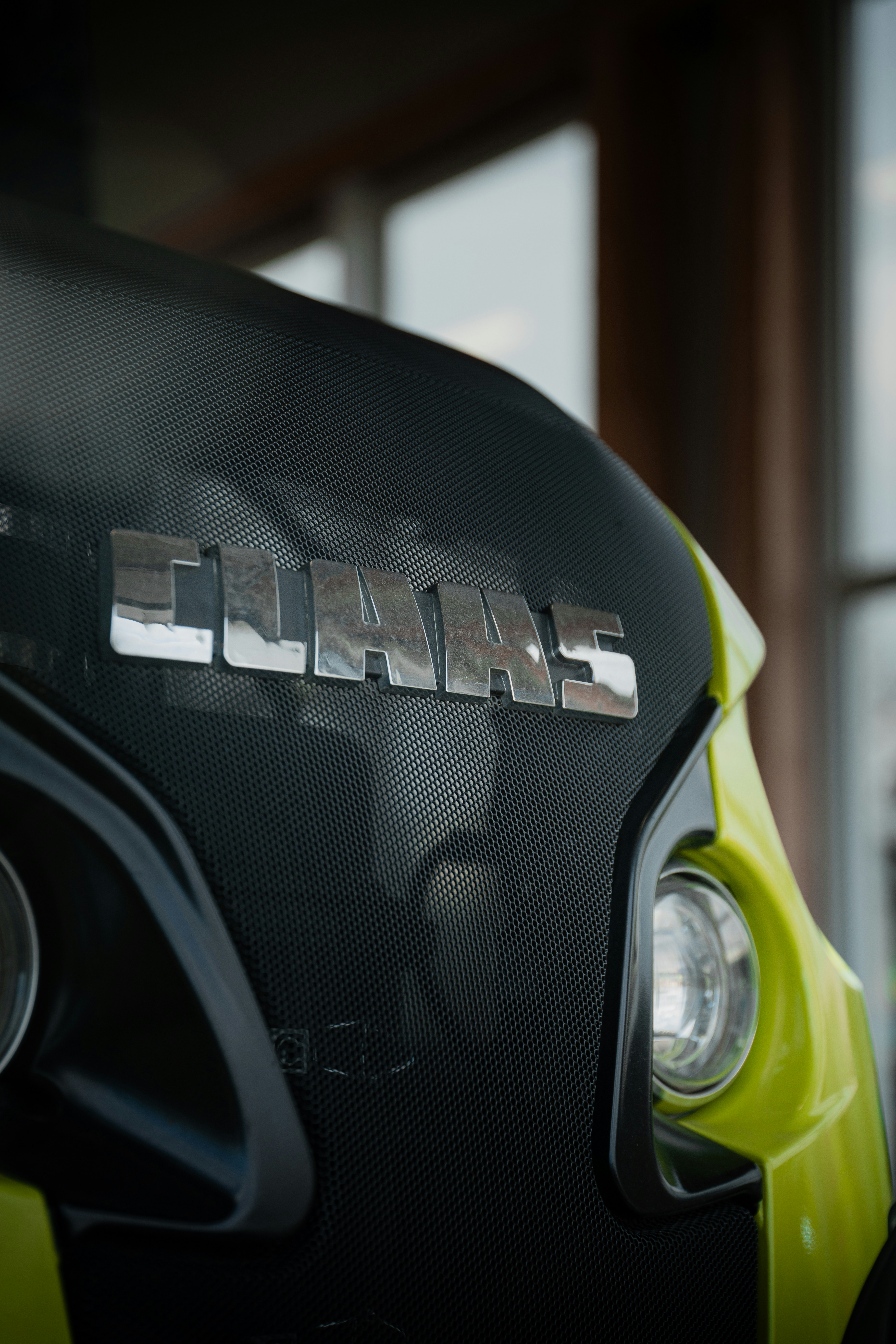 Clarity in chrome: a close-up of the CLAAS badge on lime-yellow tractor fascia
