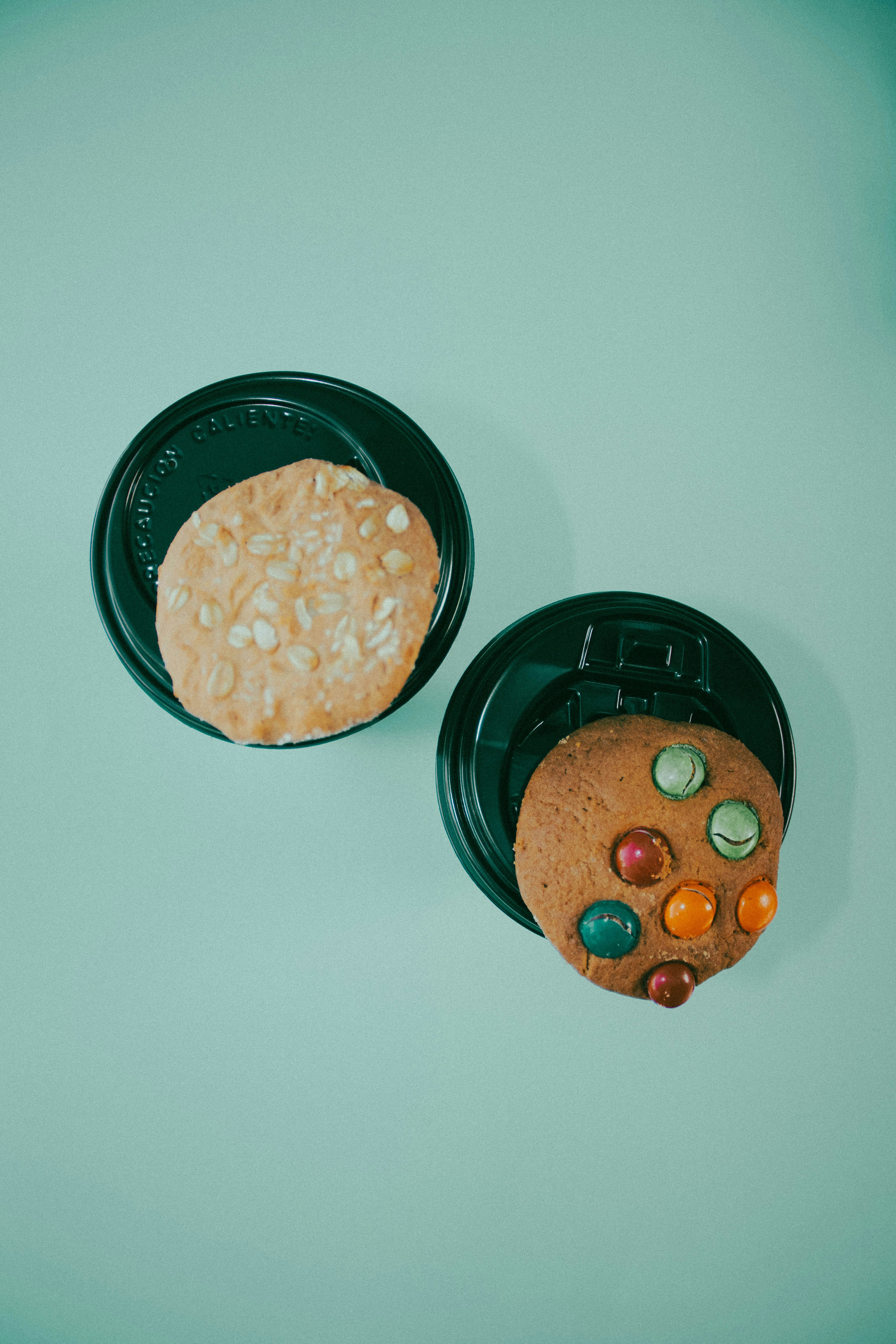 Two Chocolate-Cookie Discs in Recessed Lids on Minty Background