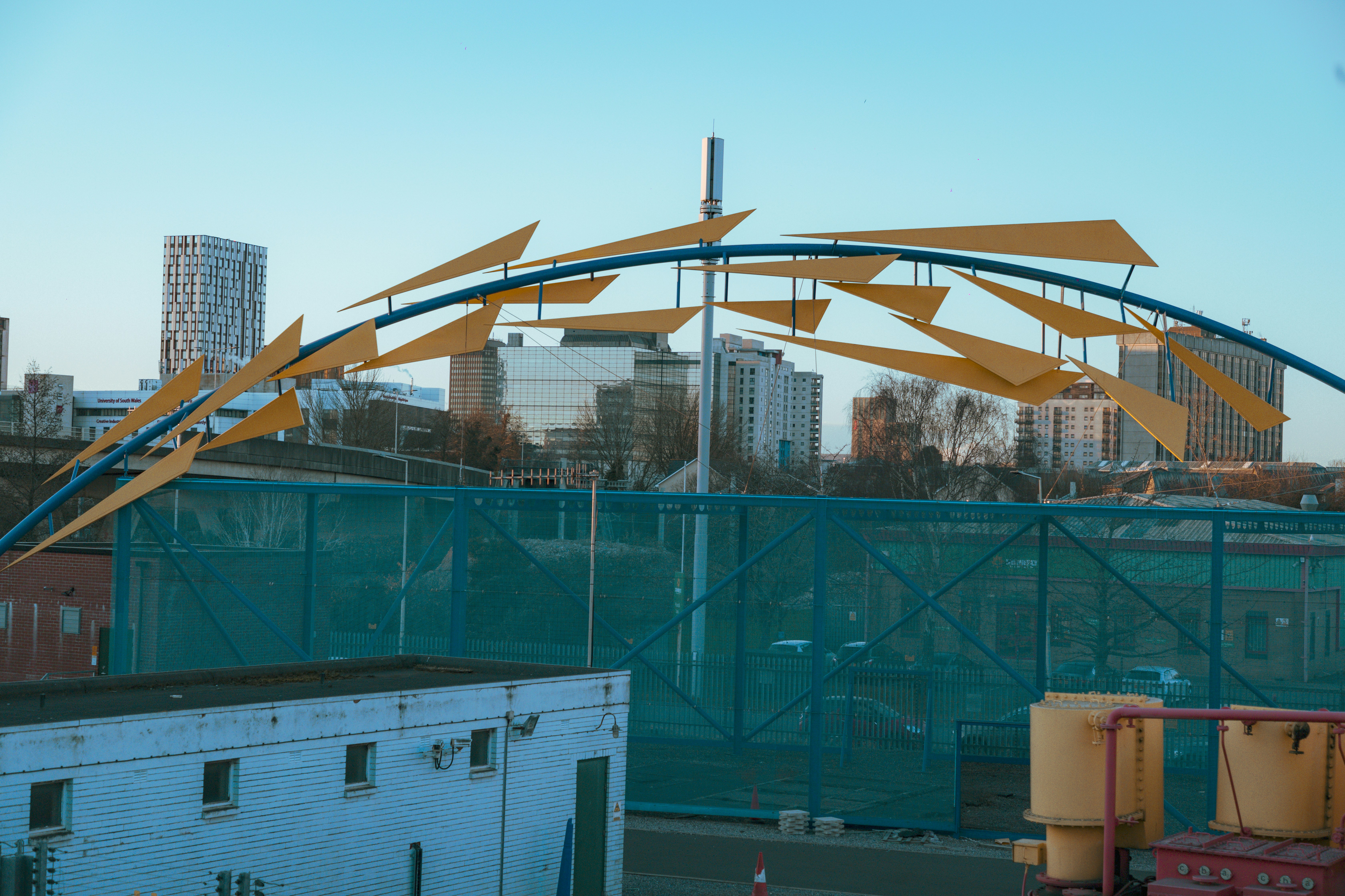 Blue Fence Horizon: Urban Sculpture against a Quiet Skyline
