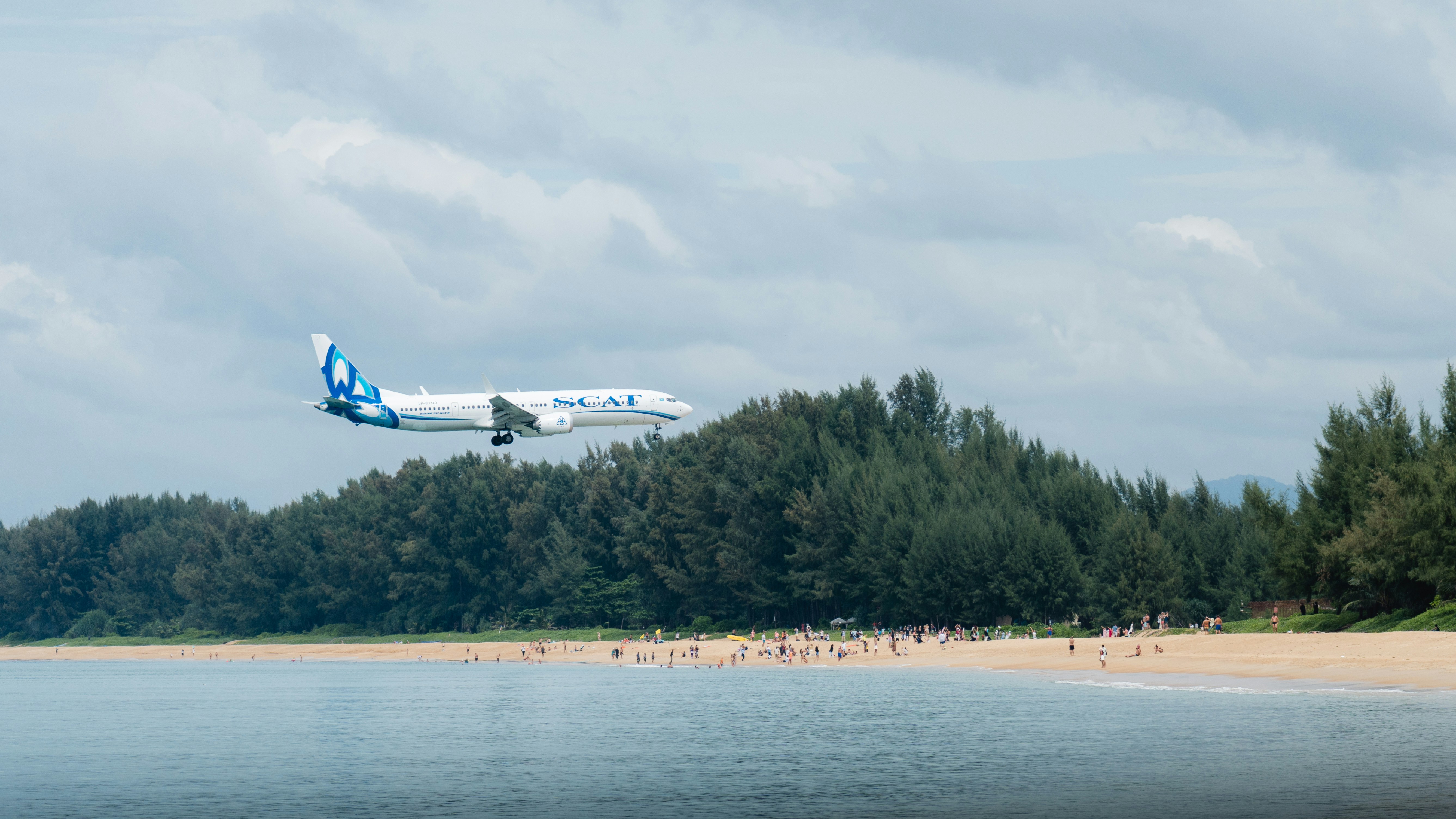 Blue-and-White Jet Skims the Beach: Takeoff Over a Sunlit Shore