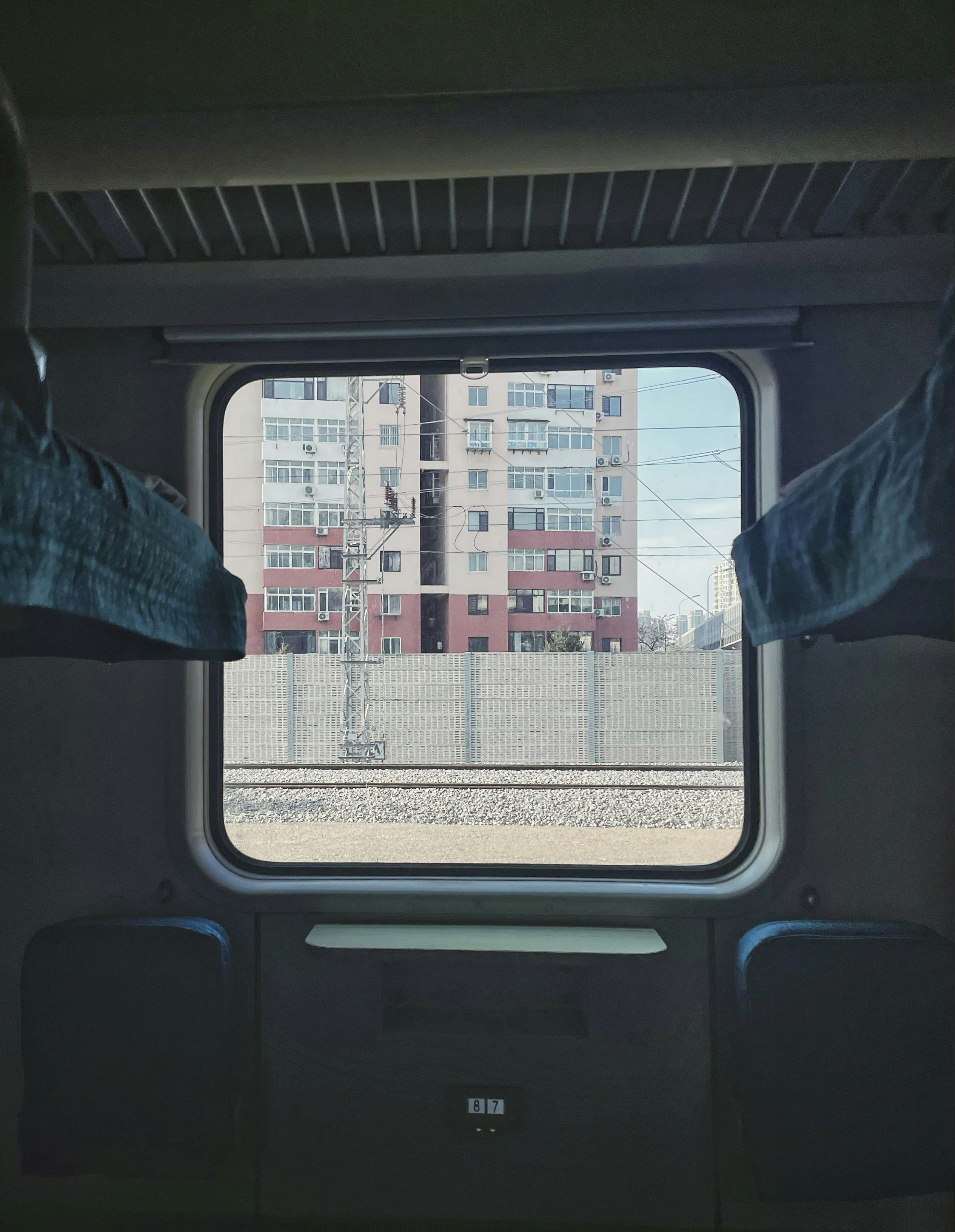 Curtain-Framed City Block: A Train-Window View of Modern Apartments