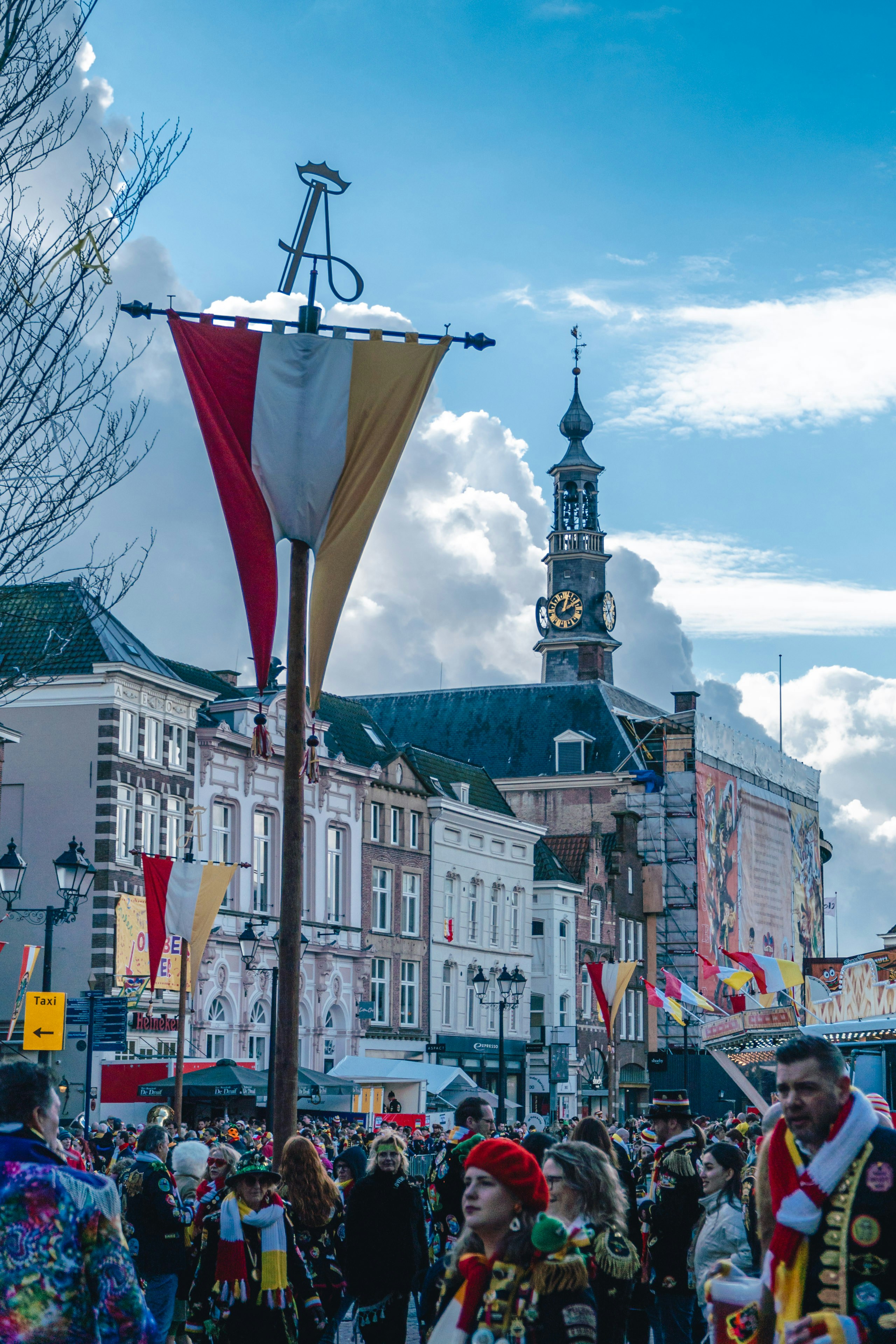 Tri-Color Banner Rises Over a Bustling Town Square Festival