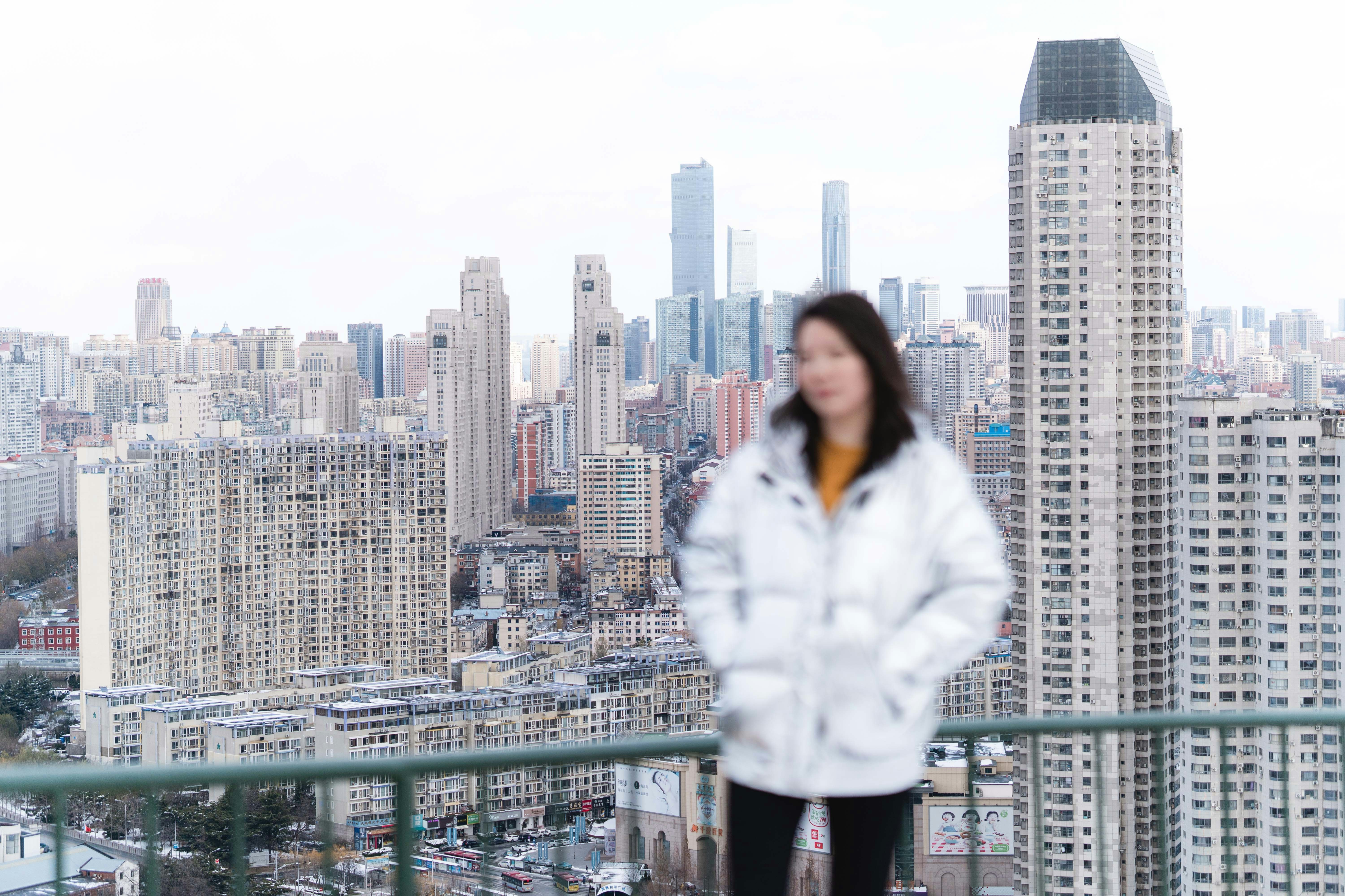A woman standing on top of a tall building photo – Free Dalian Image on ...
