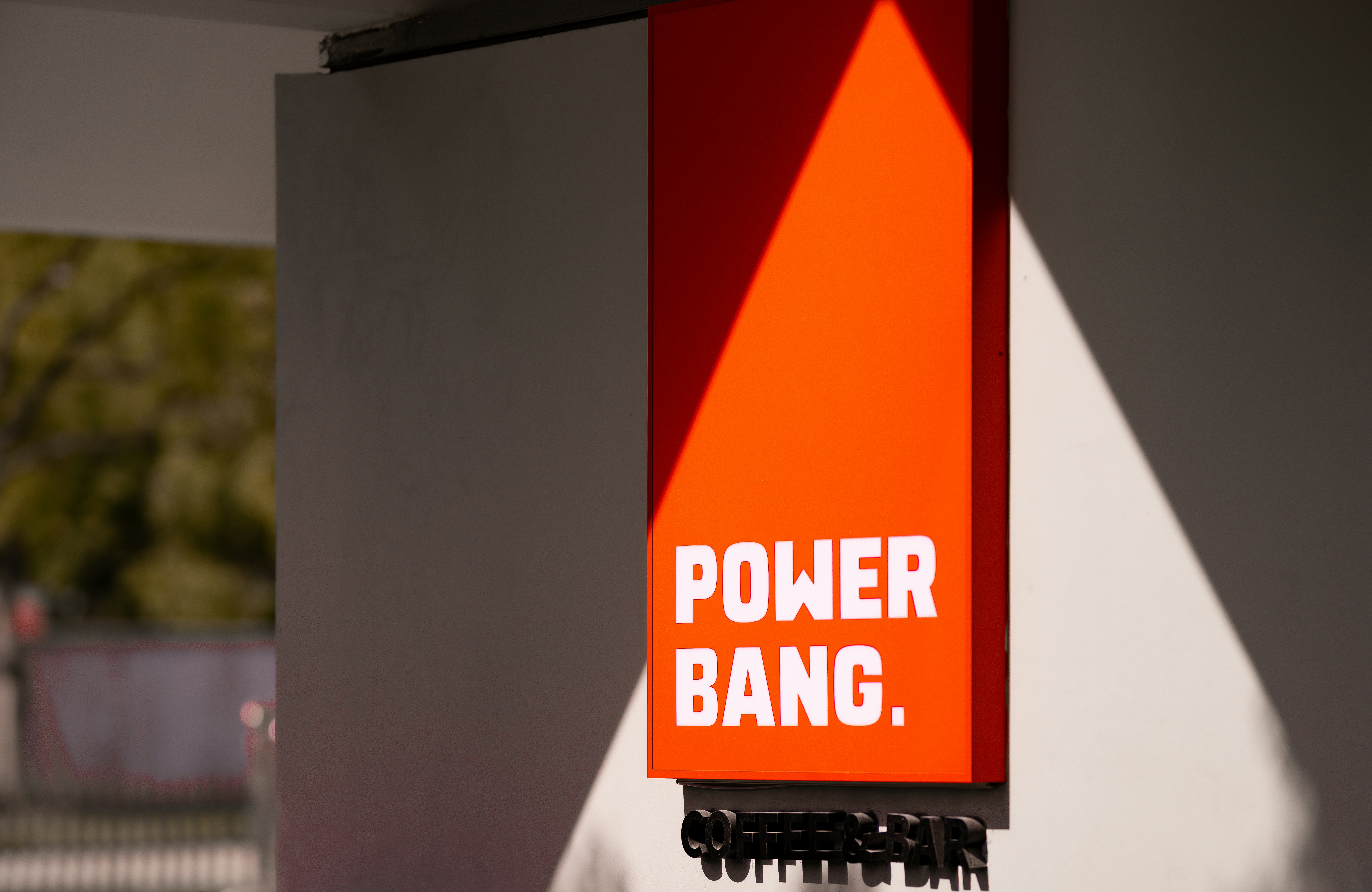 A red sign that says power bang hanging from the side of a building ...