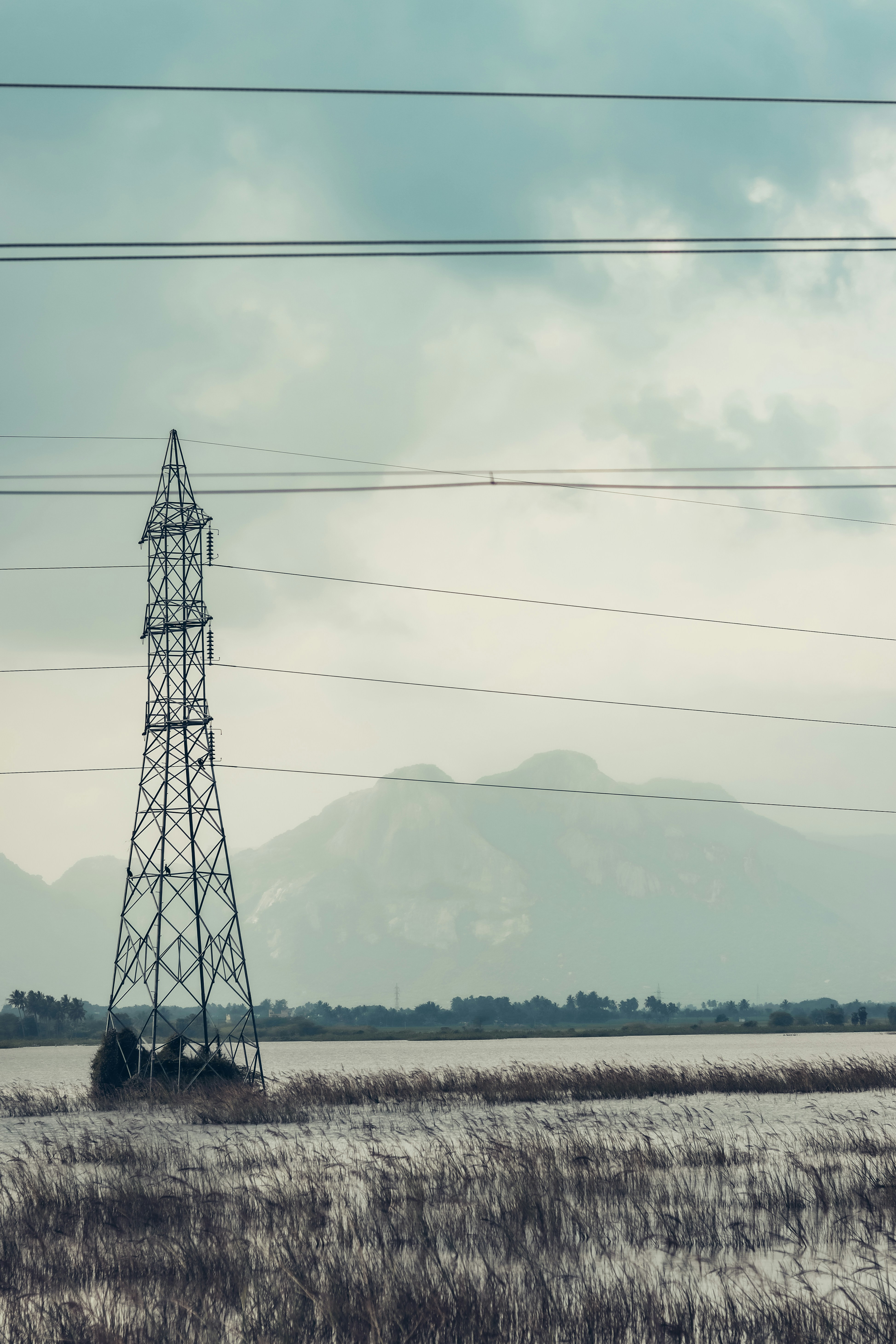 Transmission Tower Against a Misty Mountain Horizon