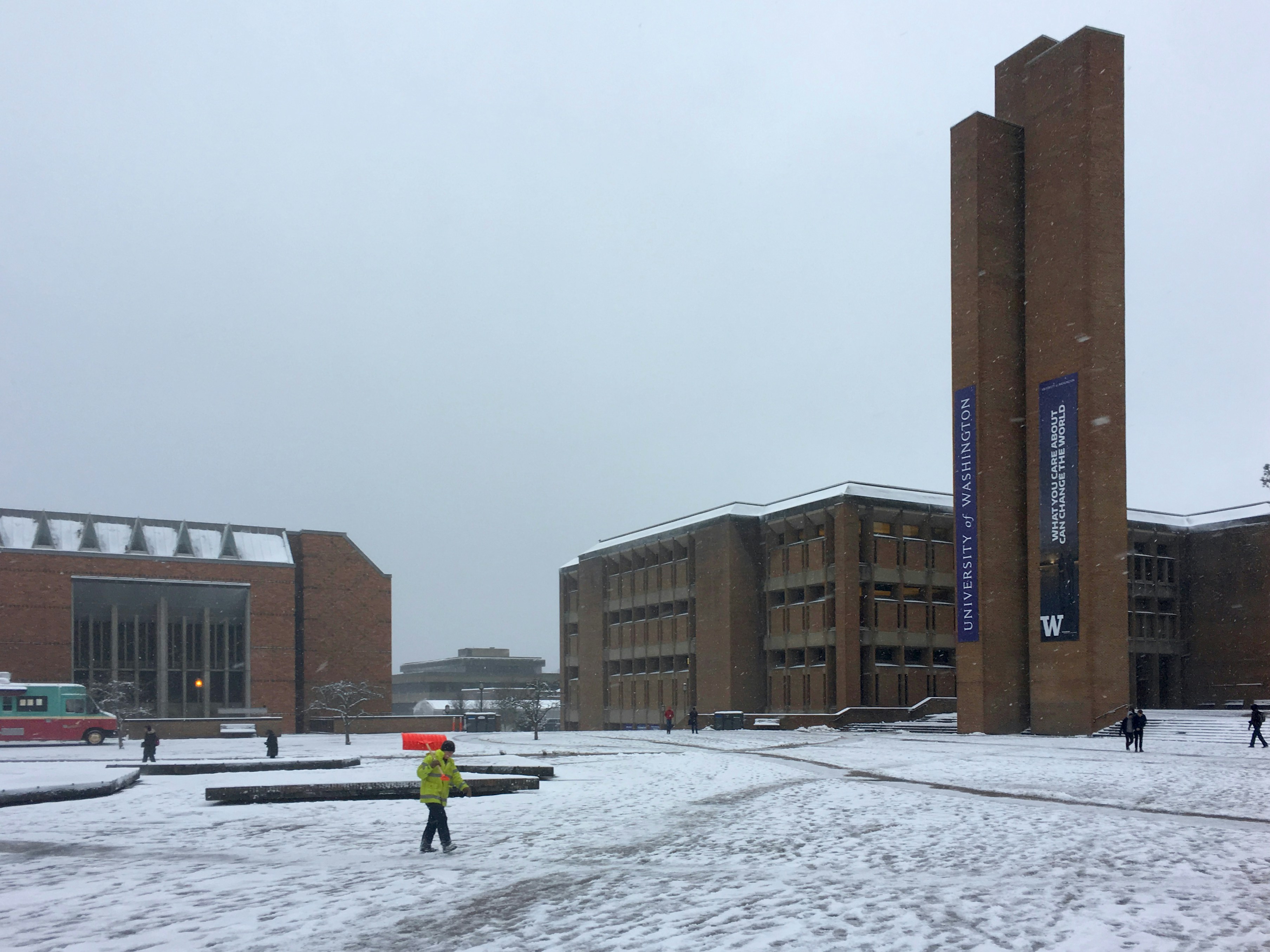 A person standing in the snow in front of a building photo – Free ...