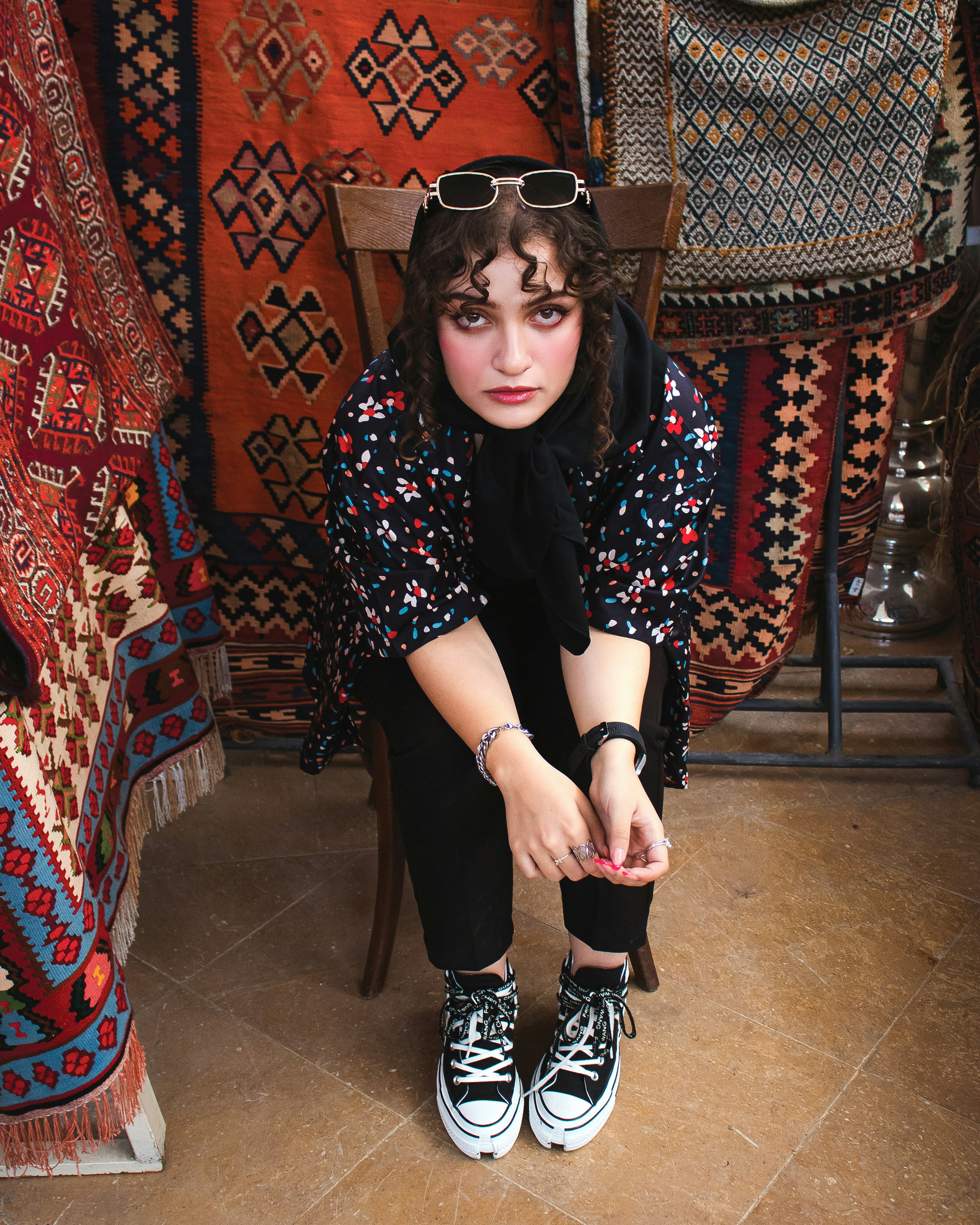 A woman sitting on the floor in front of rugs photo – Free Portrait ...