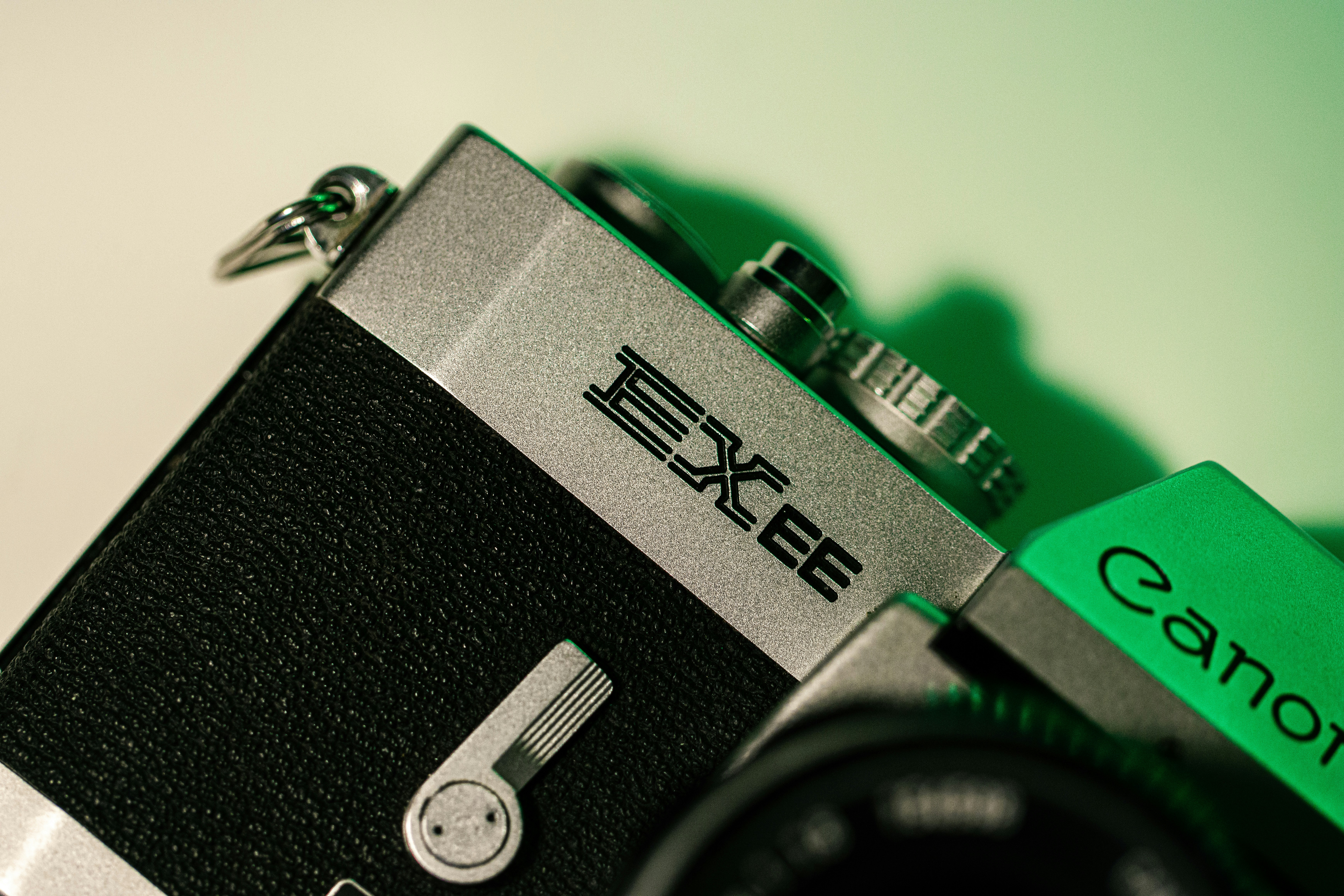 Silver-Topped Mechanism: A Close-Up of a Vintage Camera with a Neon Canon Label