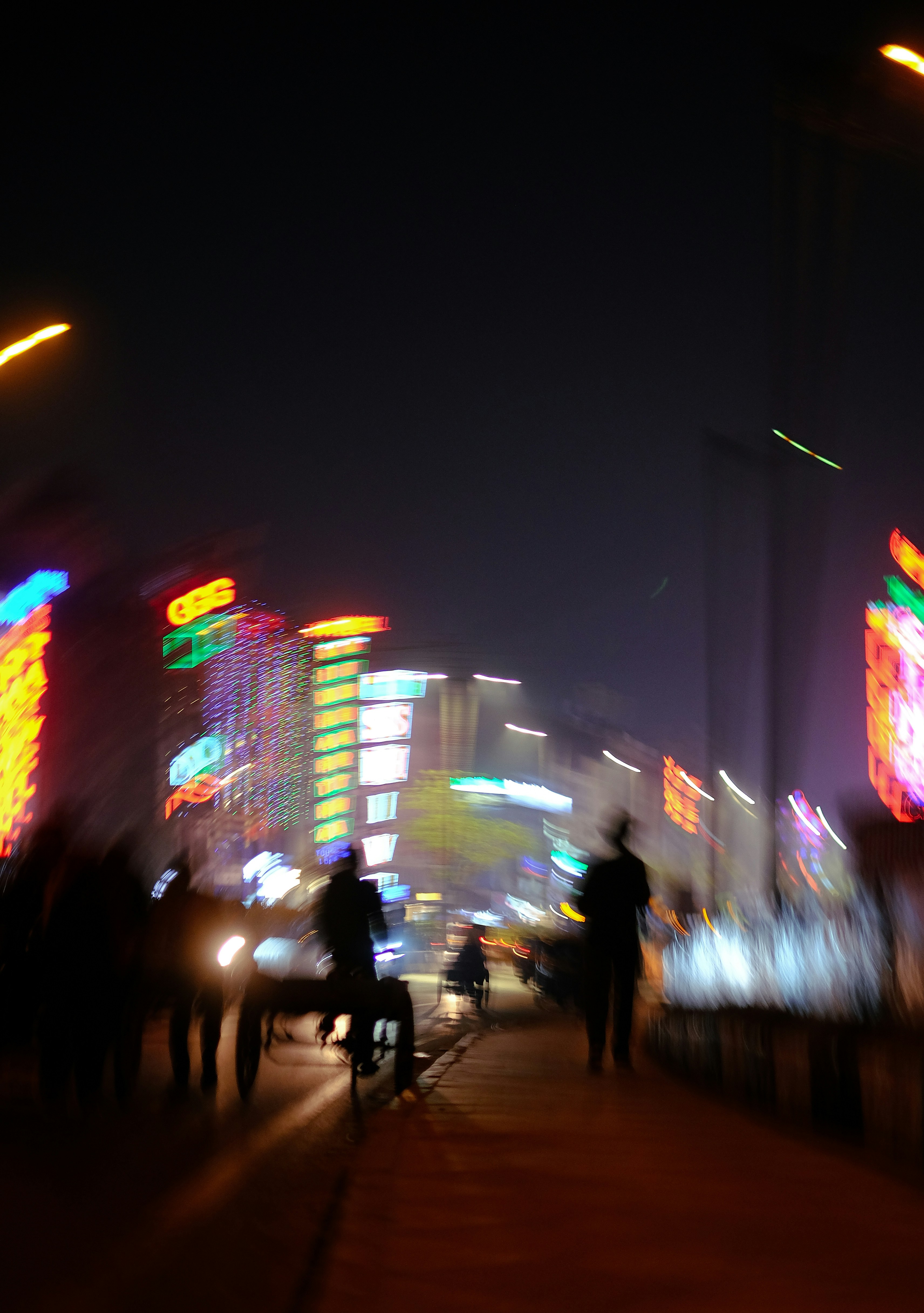 A group of people walking down a street at night photo – Free Street ...