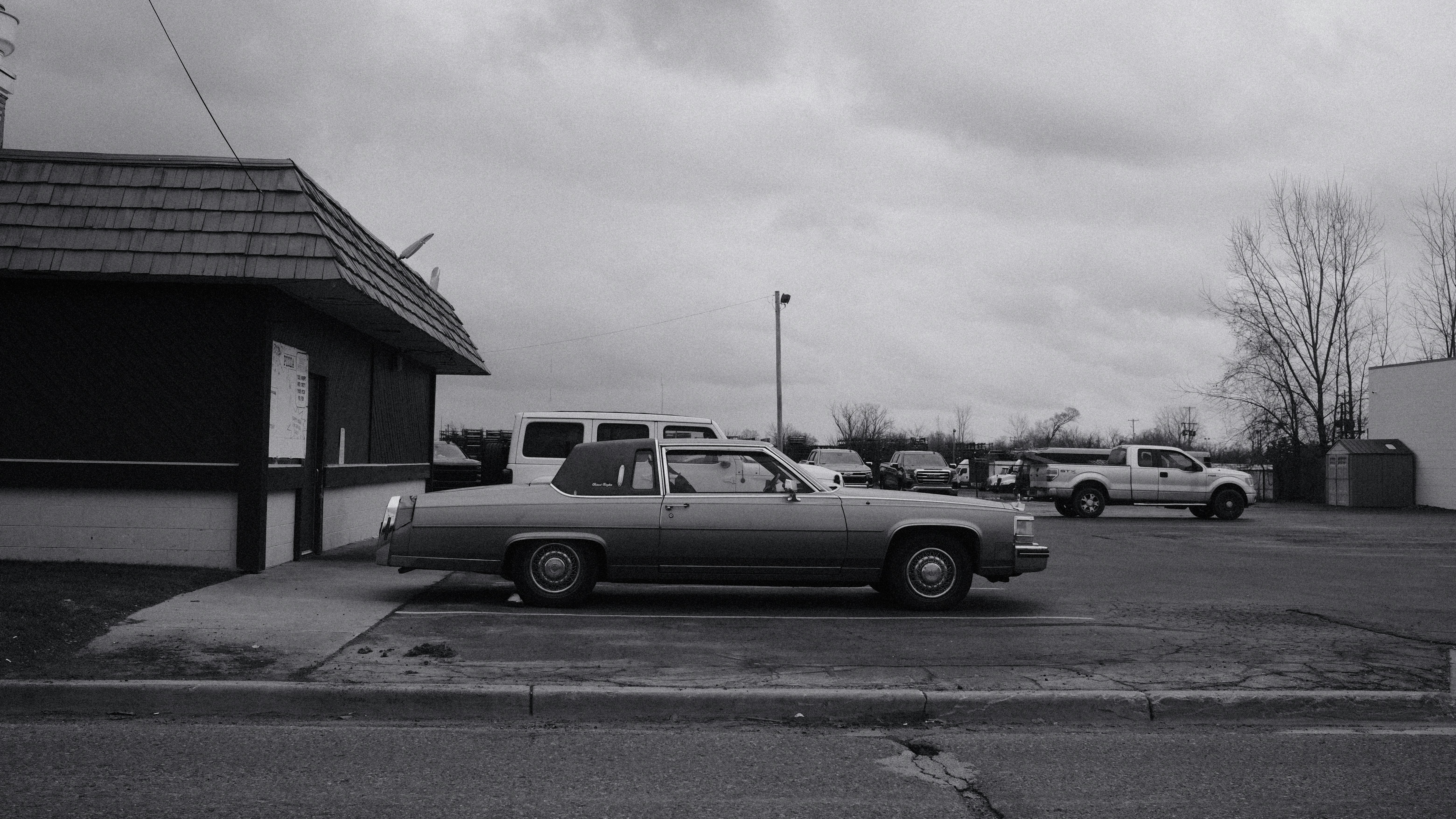 Midcentury Sedan Anchors a Quiet Parking Lot in Monochrome
