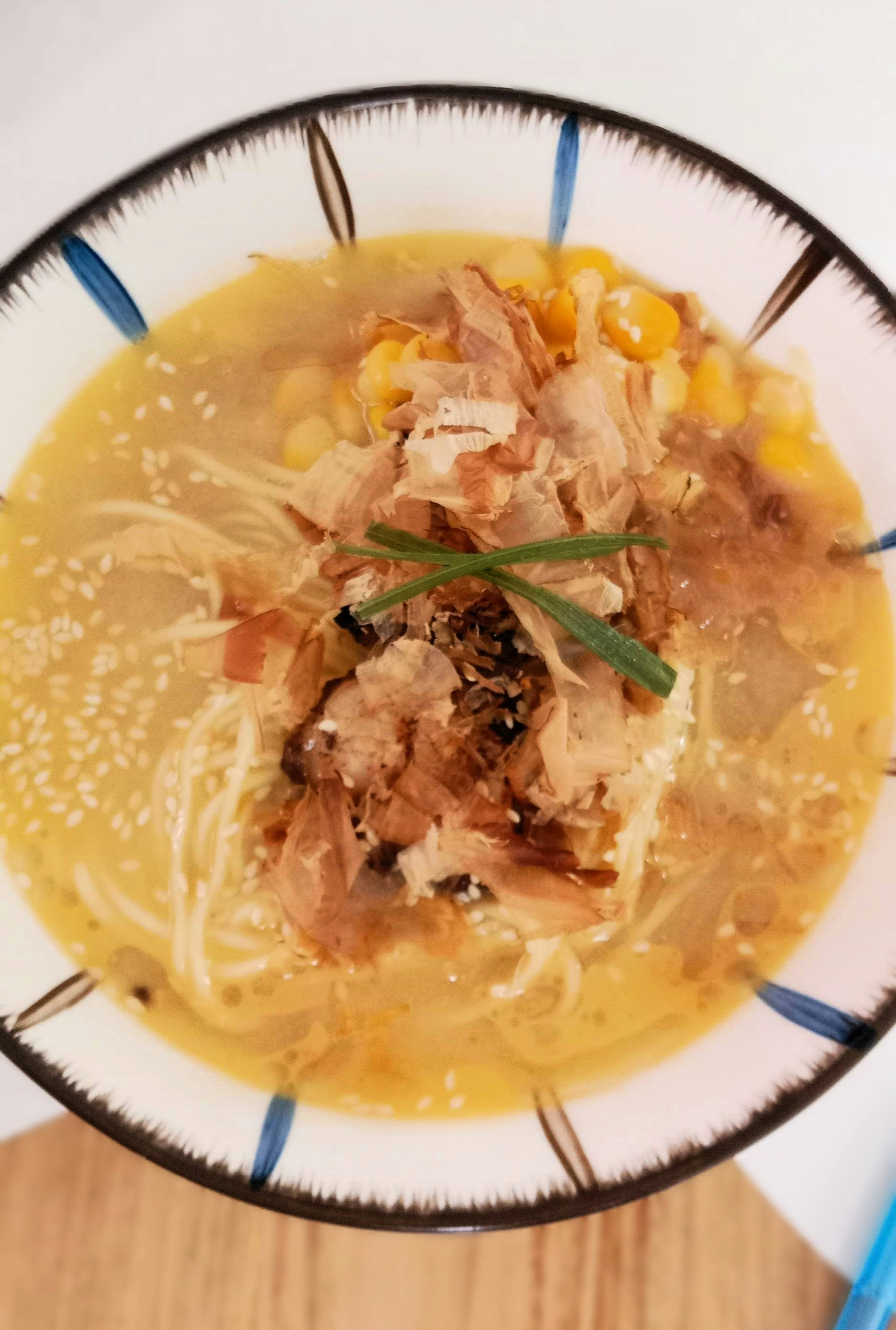 Delicious ramen topped with tender chicken, fragrant herbs, and a sprinkle of bonito flakes, served in a decorative bowl. Perfectly captures the essence of Japanese cuisine.