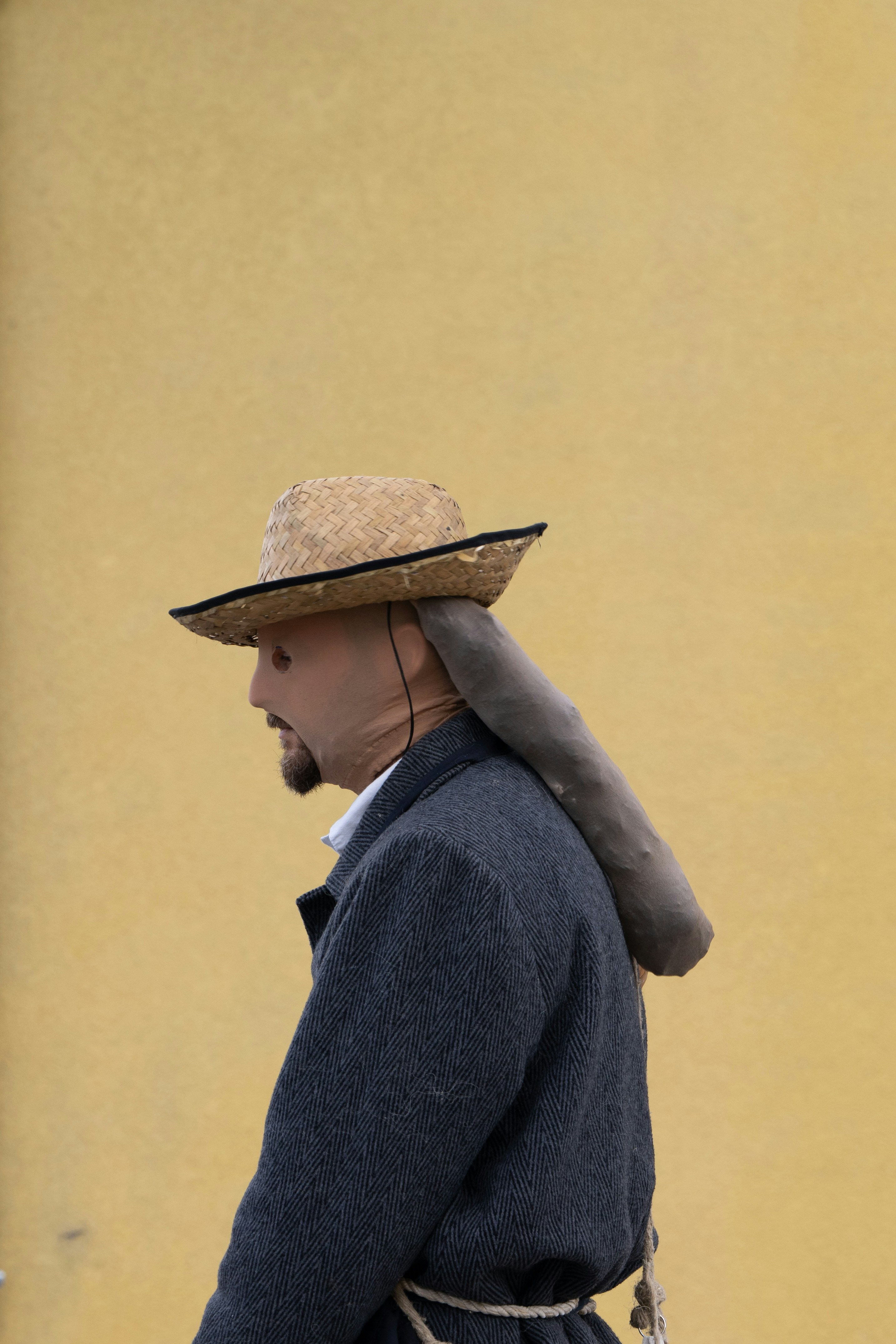 Profile in Straw: A Quiet Portrait Against an Ochre Wall