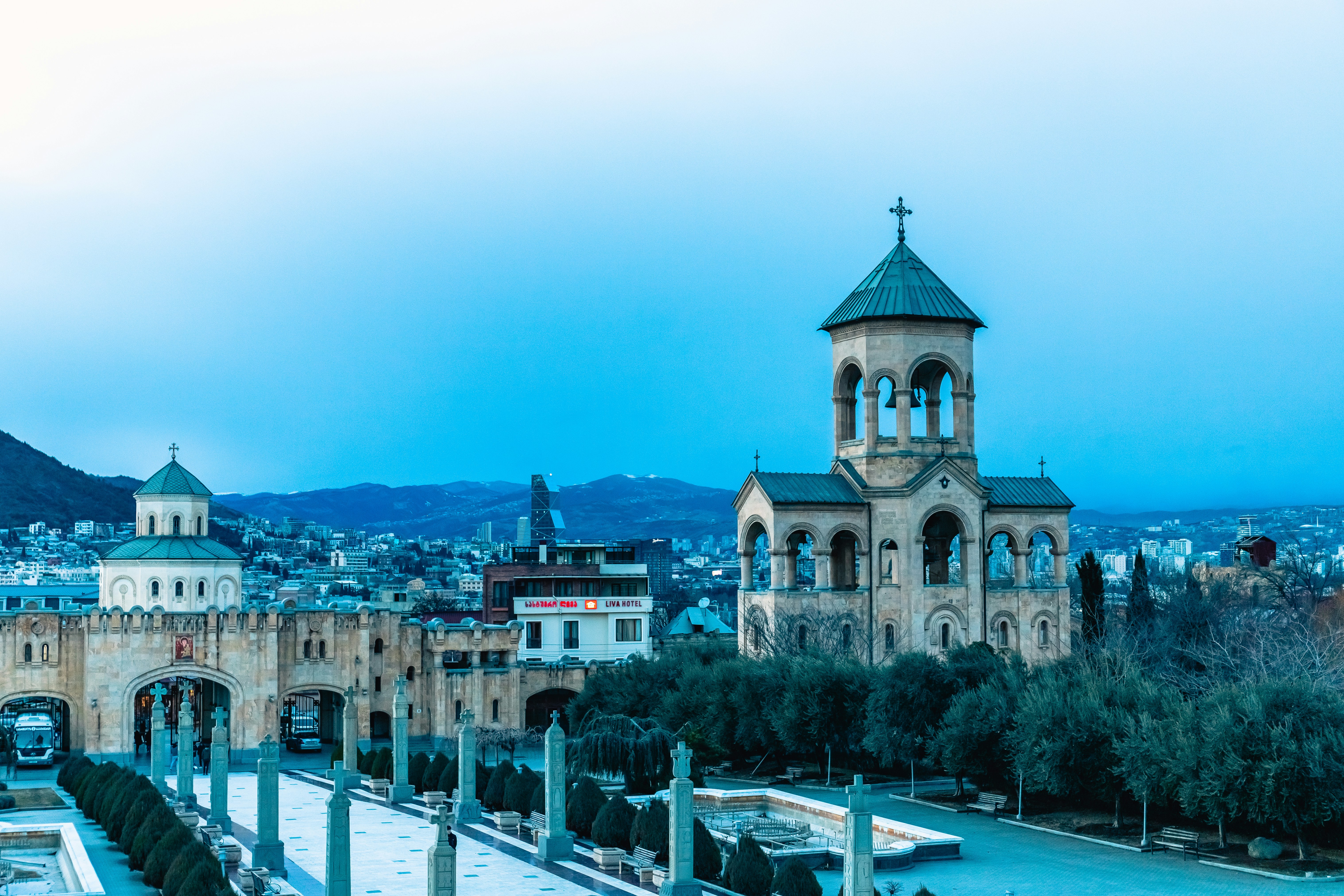 Trinity Cathedral in Tbilisi at sunset | a large building with a clock tower on top of it