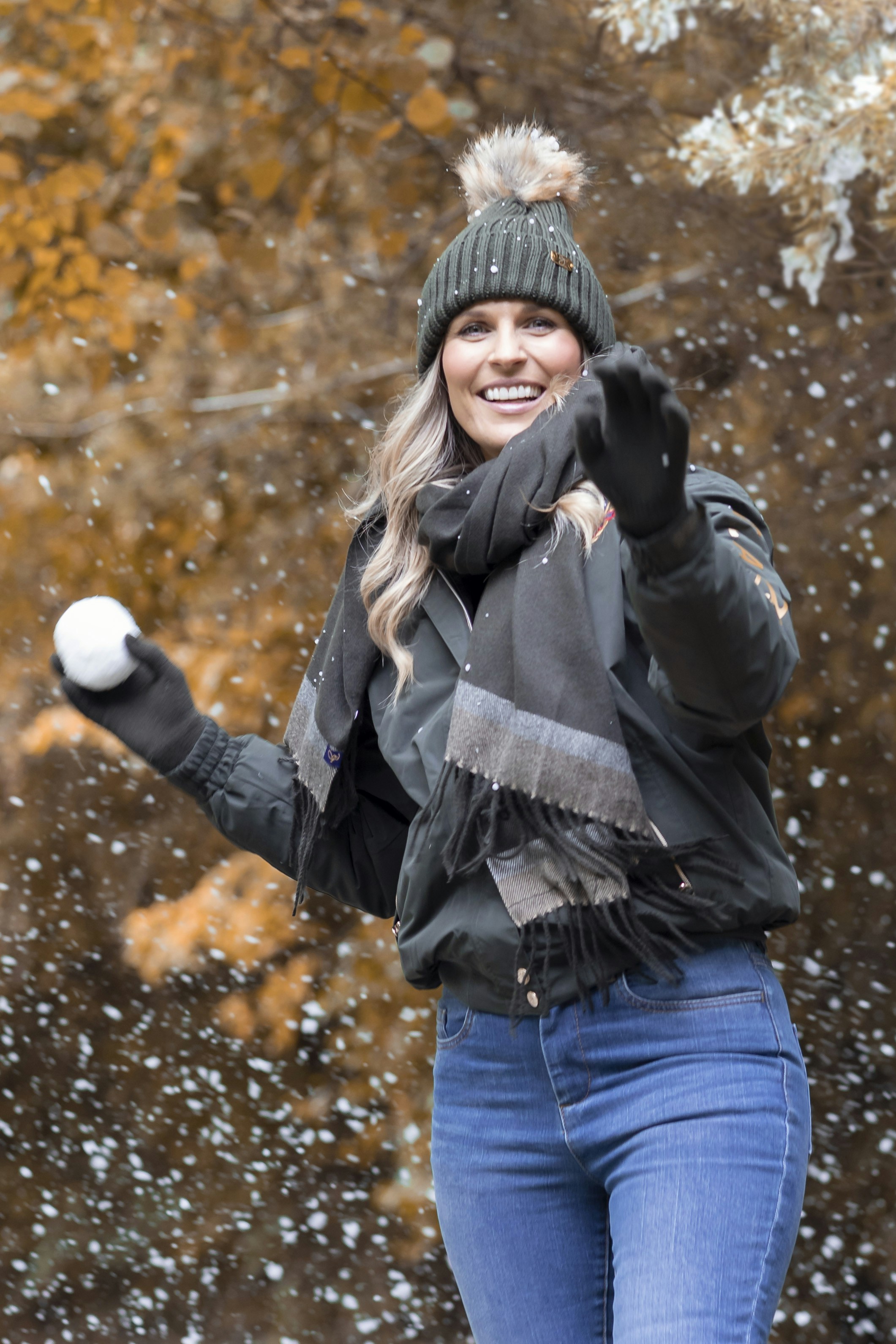 A woman in winter clothing throwing a snowball photo – Free Lady ...