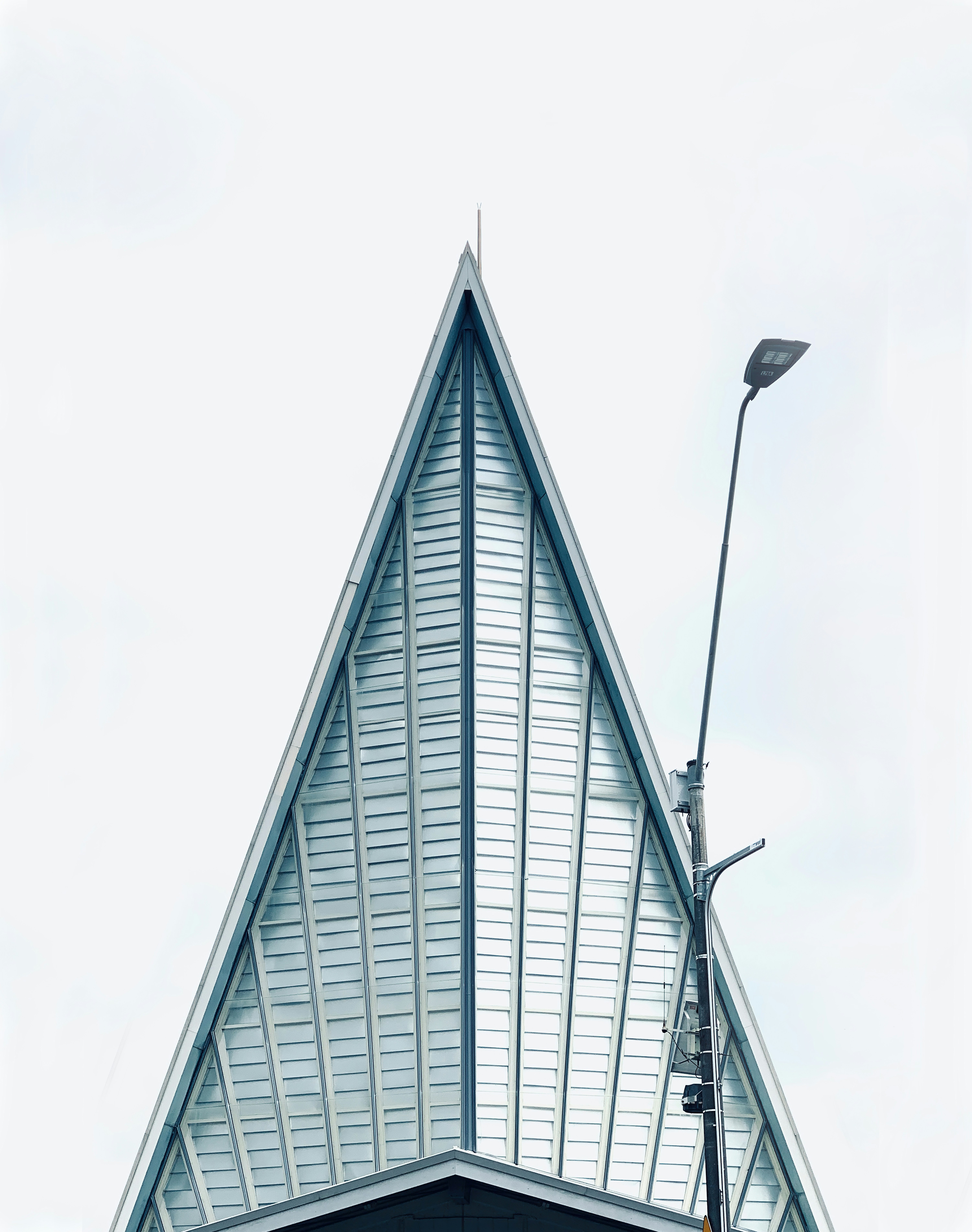 Blue-Gable Summit Under a Bleached Sky with a Lone Street Lamp