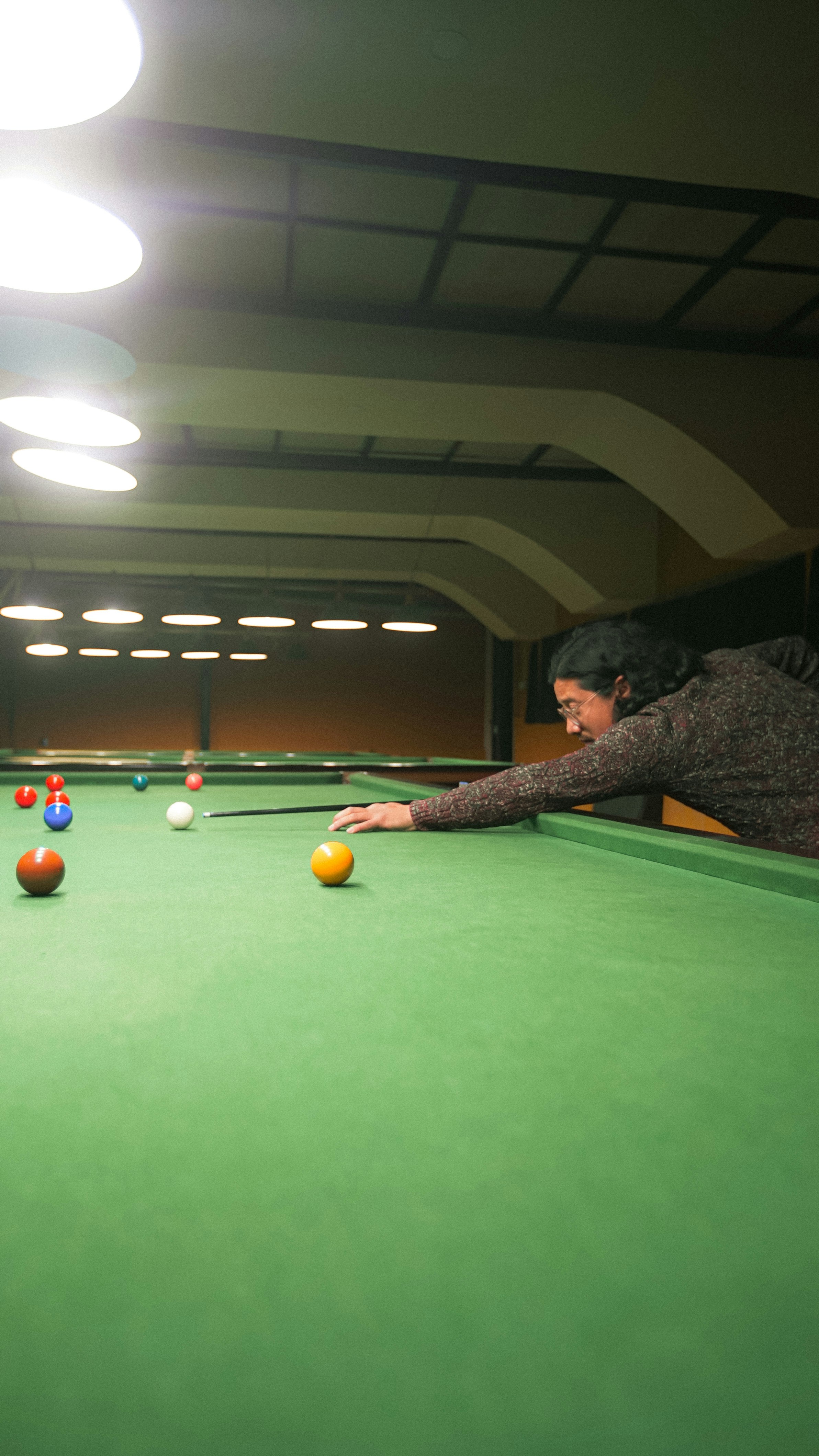 A man leaning over a pool table to hit a ball photo – Free 4k Image on ...