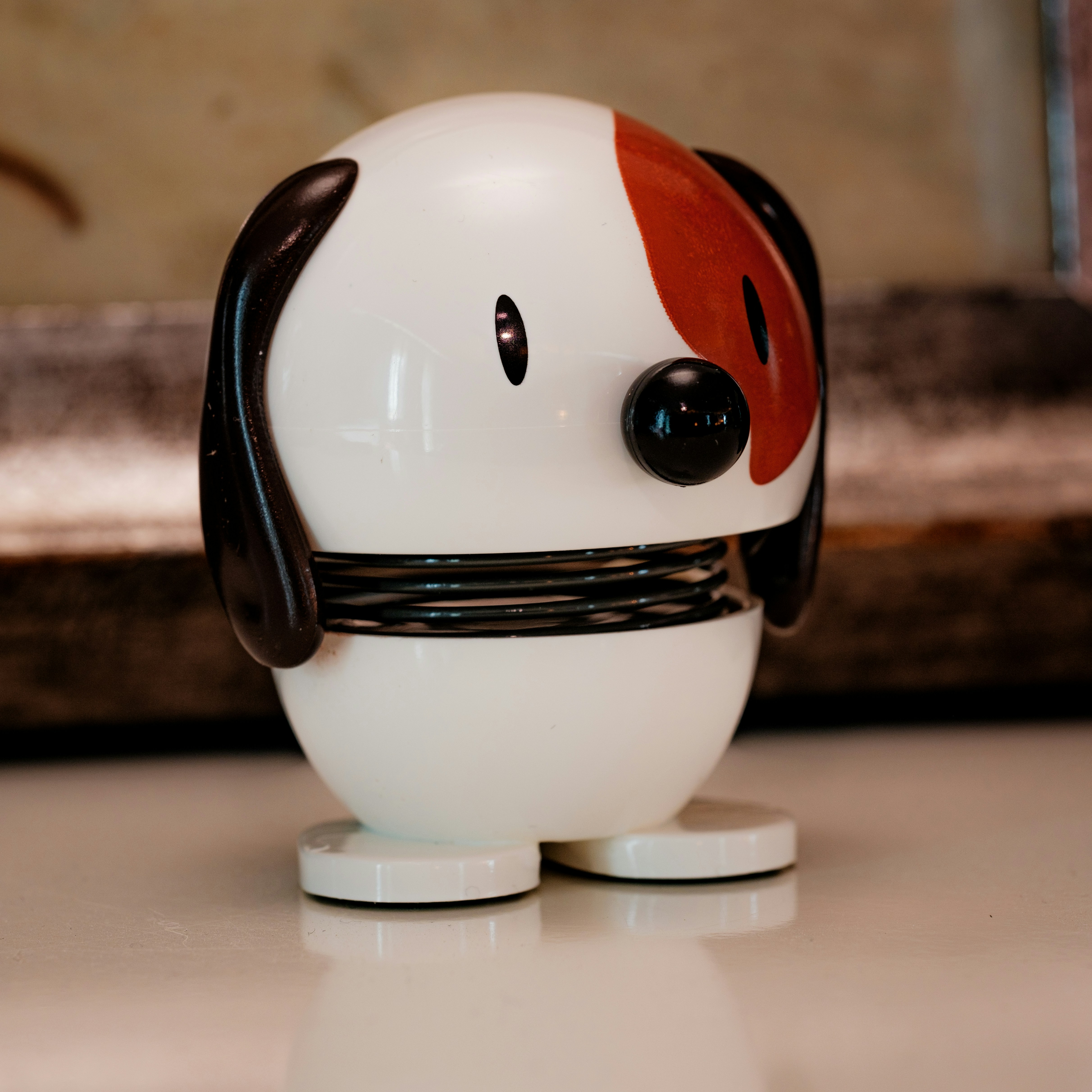 Snoopy-Inspired Desk Buddy: A Glossy White Figurine with Black Ears and a Red Patch