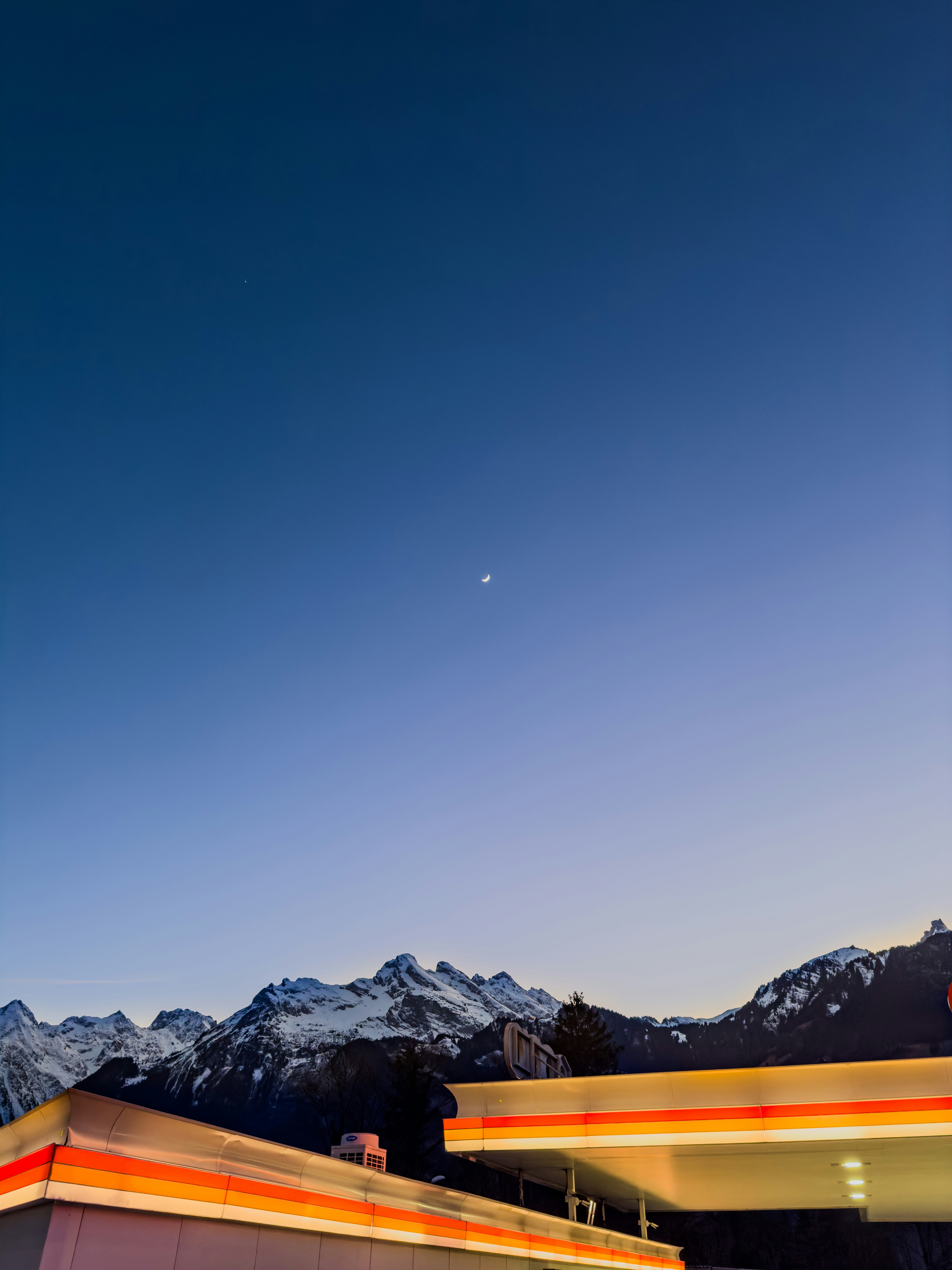 Moonlit Sky Over Snow-Capped Peaks at Sunset T Station