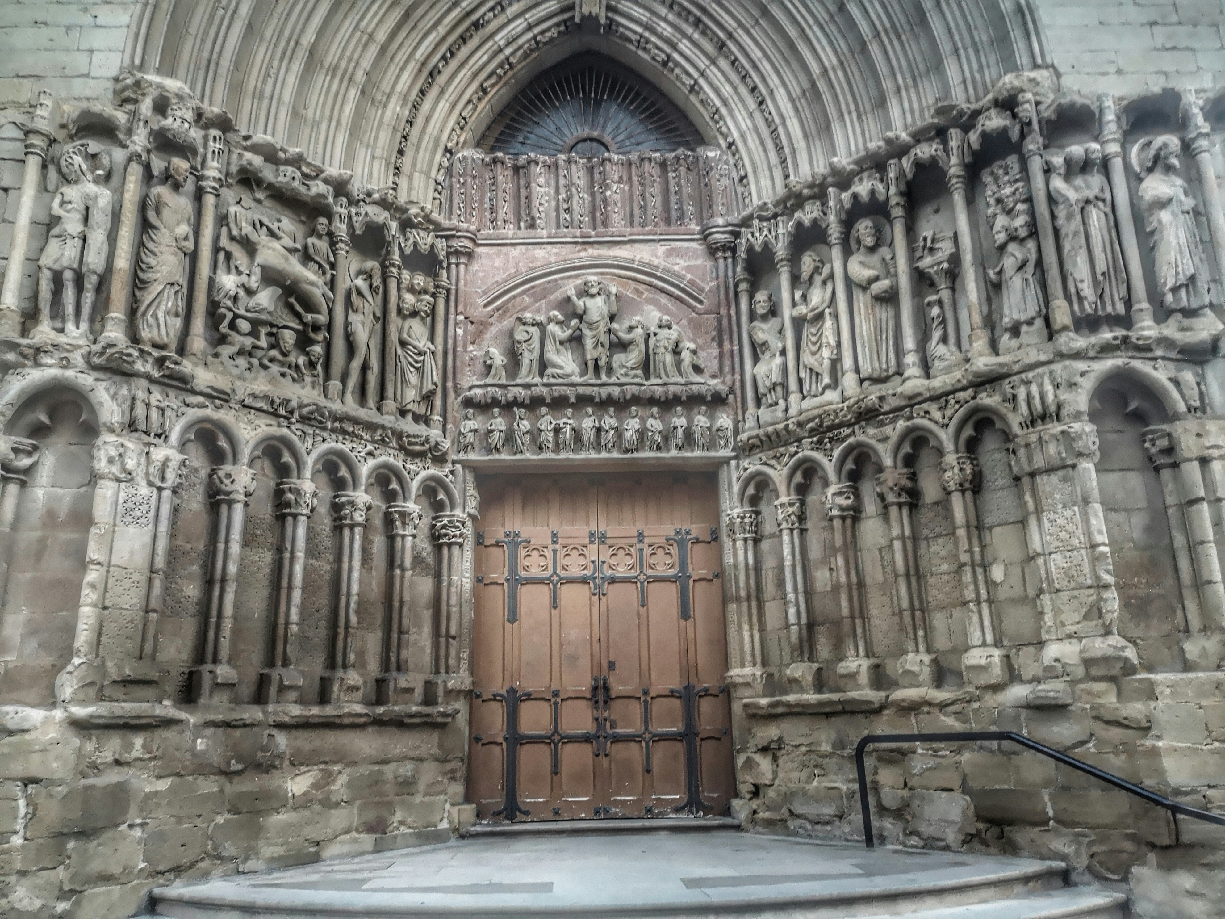 A large stone building with a wooden door photo – Free Grey Image on ...