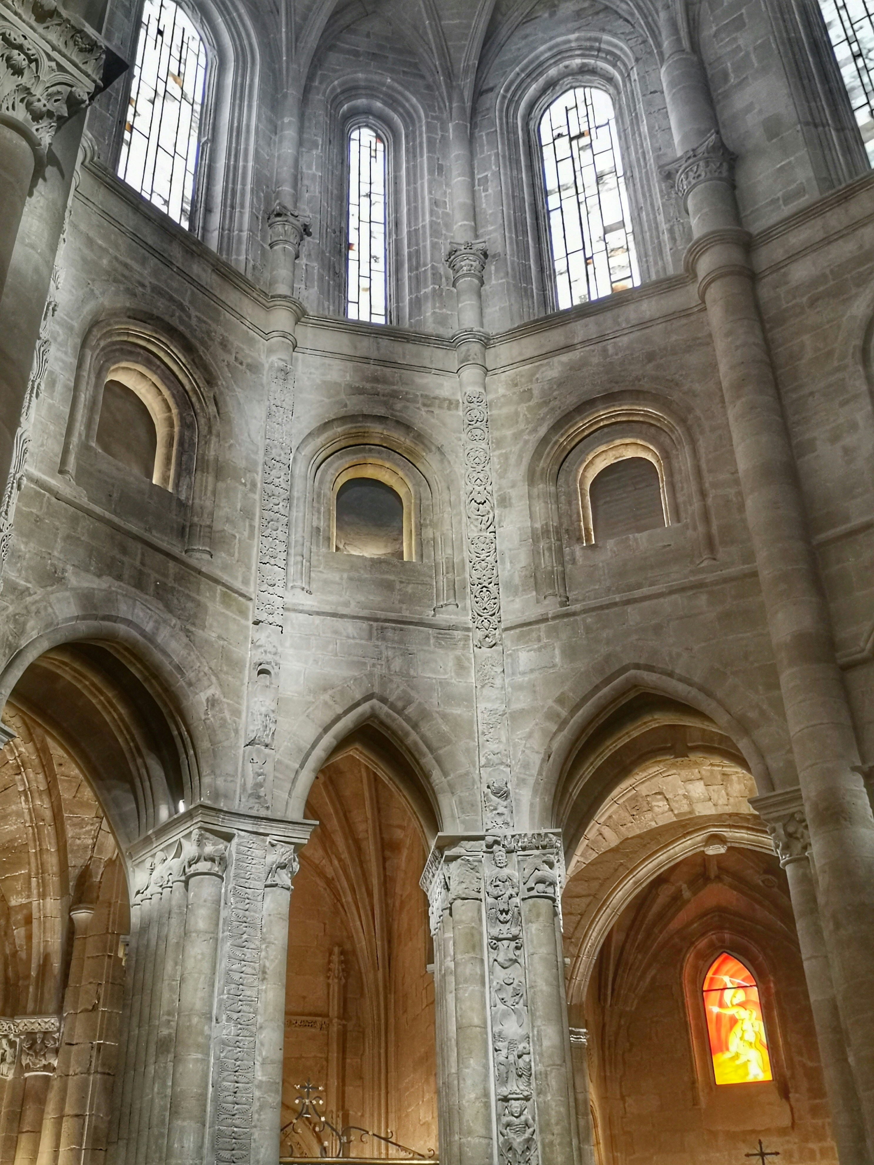 A large cathedral with high vaulted ceilings and stained glass windows ...