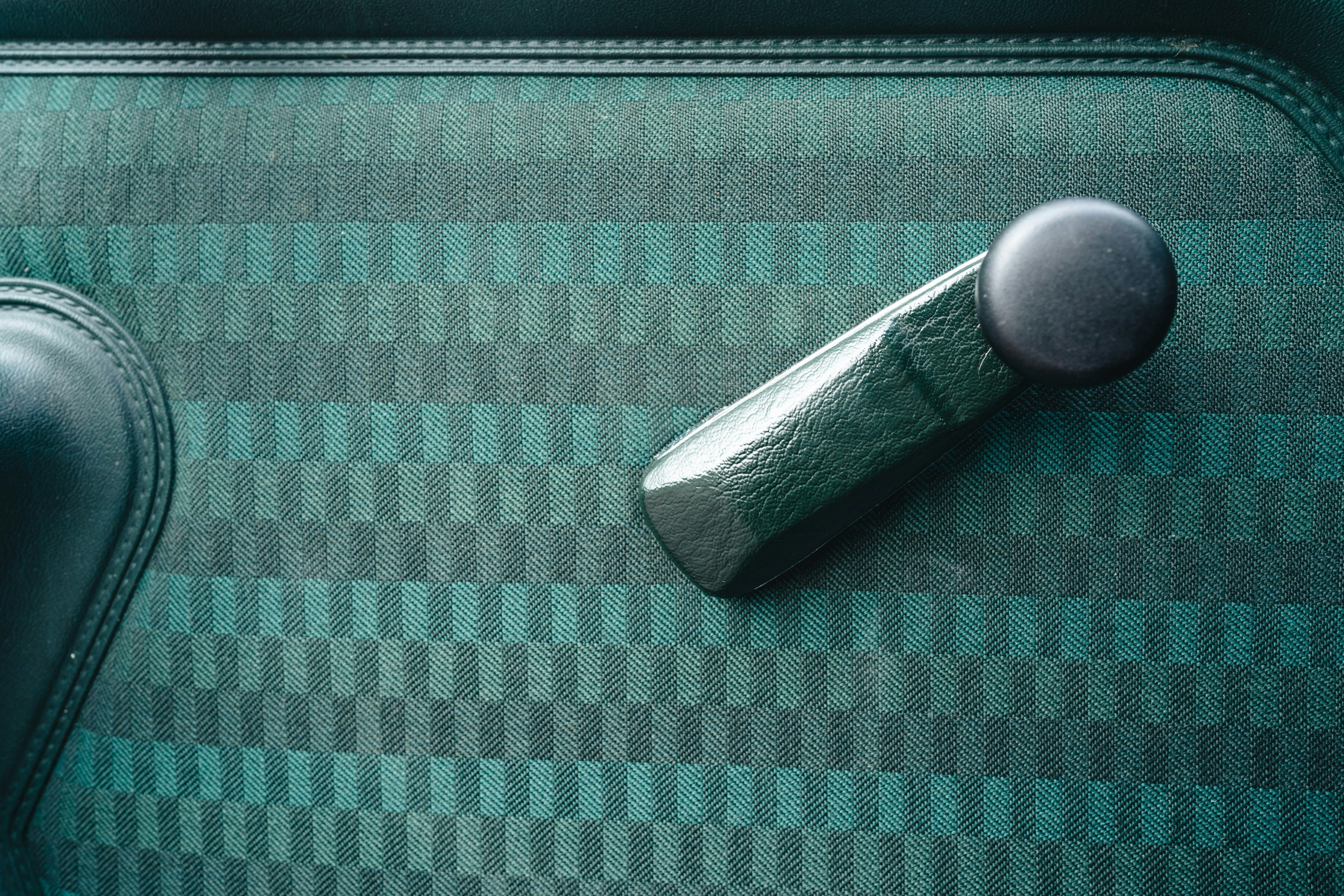 Teal Checkered Fabric with a Leather Zipper Pull: A Close-Up Study
