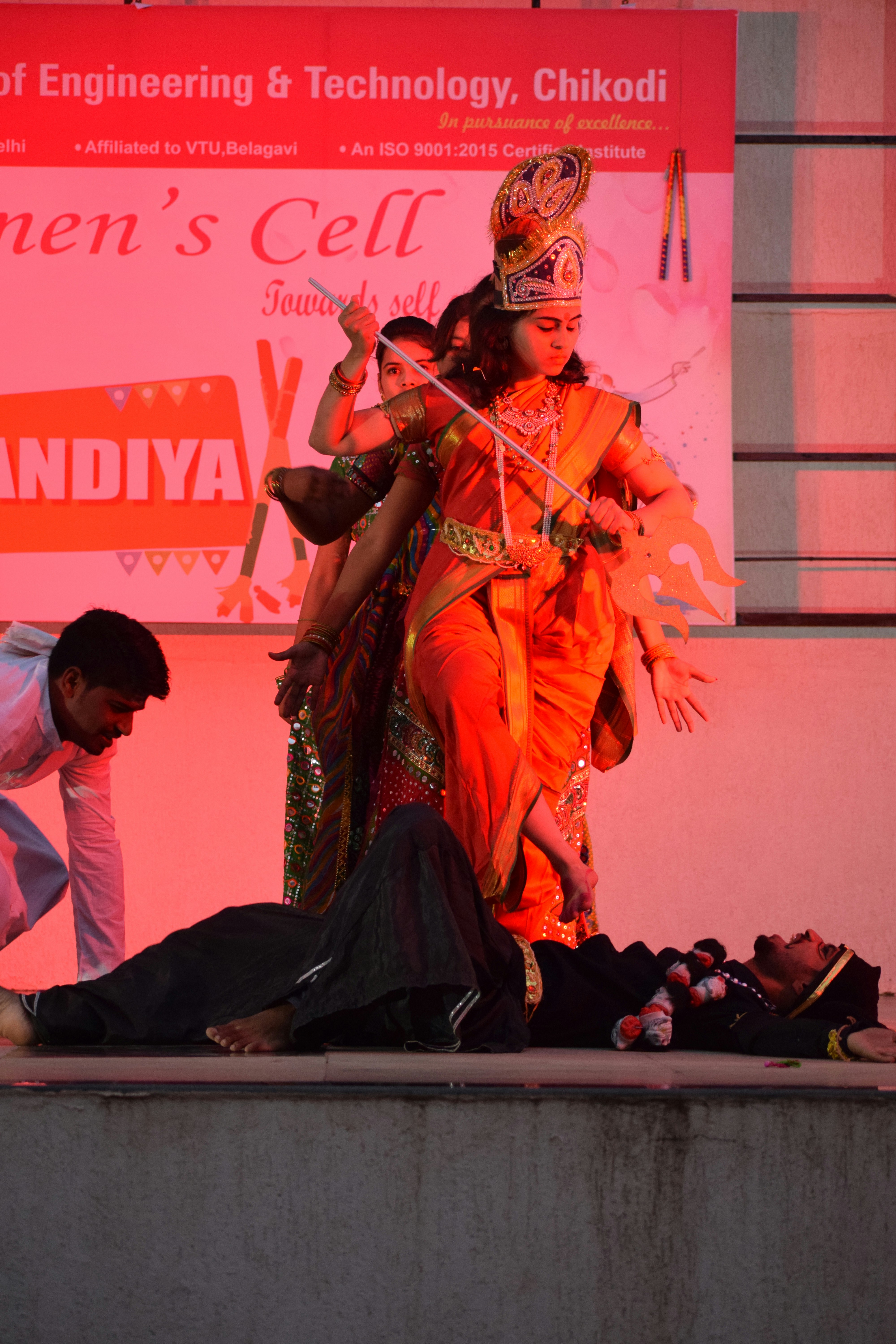 Festive Bharatanatyam Pose on Stage with Dramatic Red Backdrop