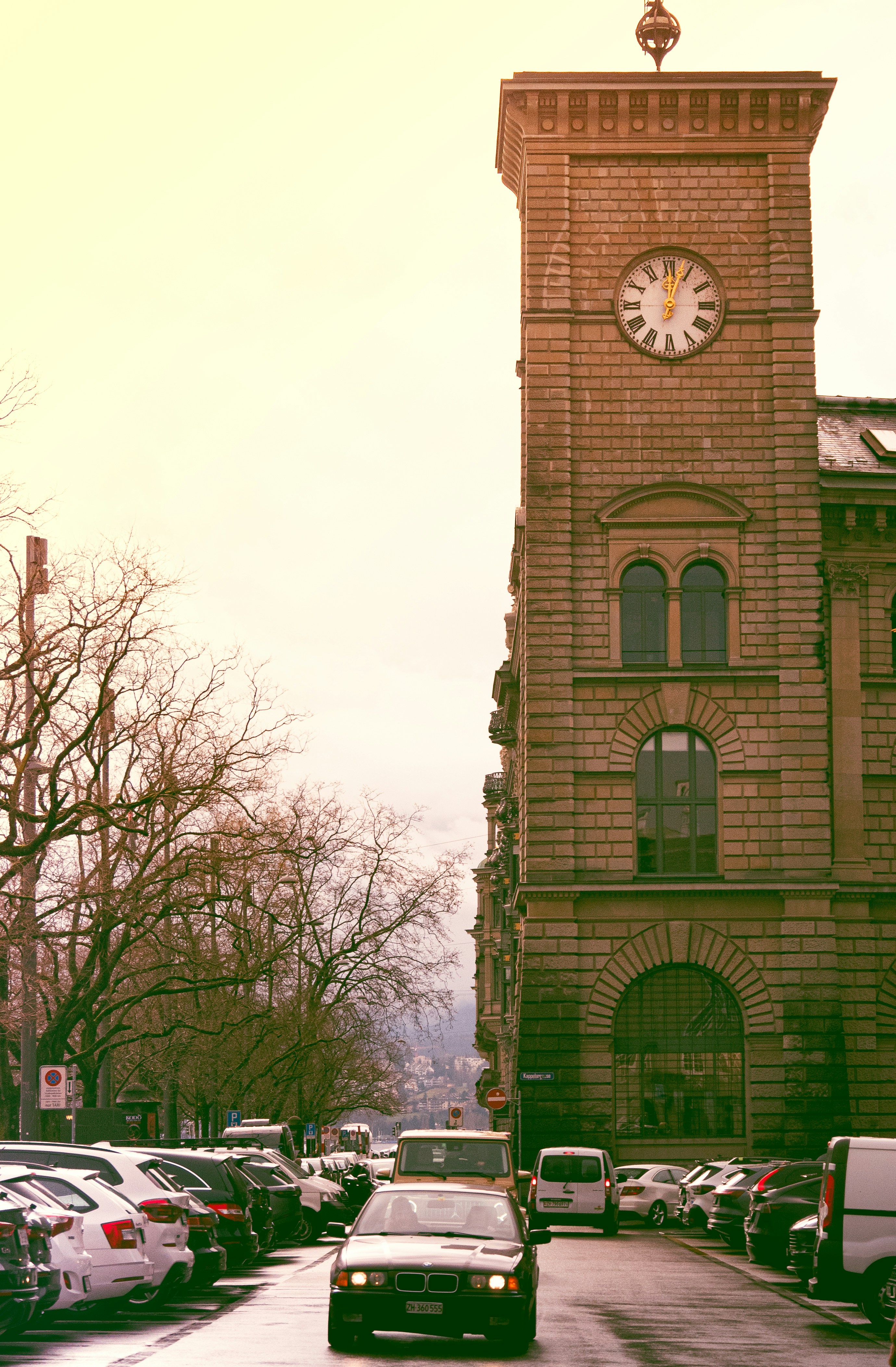 Sepia Clocktower at the Edge of a Car-Lined Street