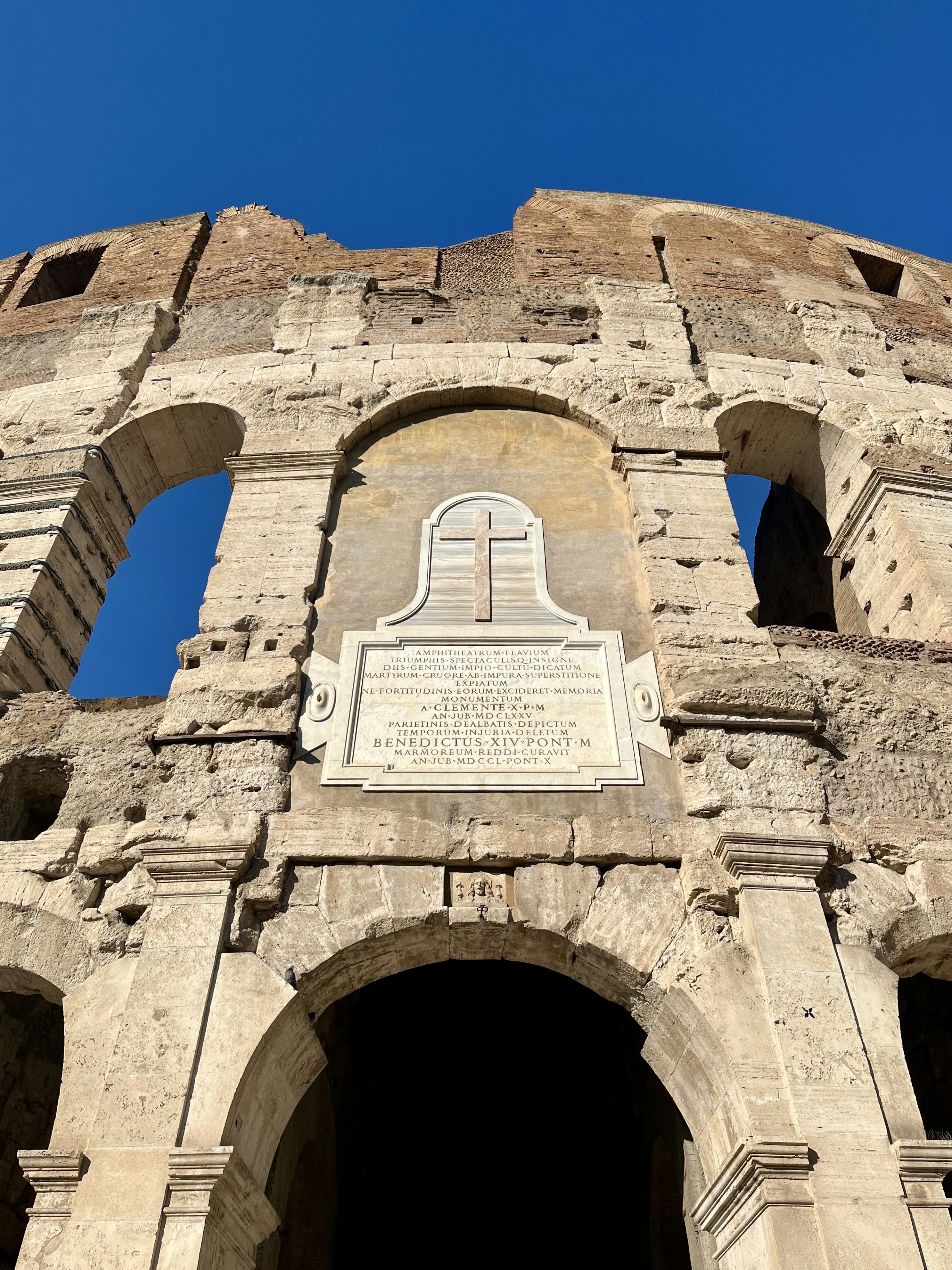 Sunlit Keystone: A Timeworn Archway with an Inscribed Tablet
