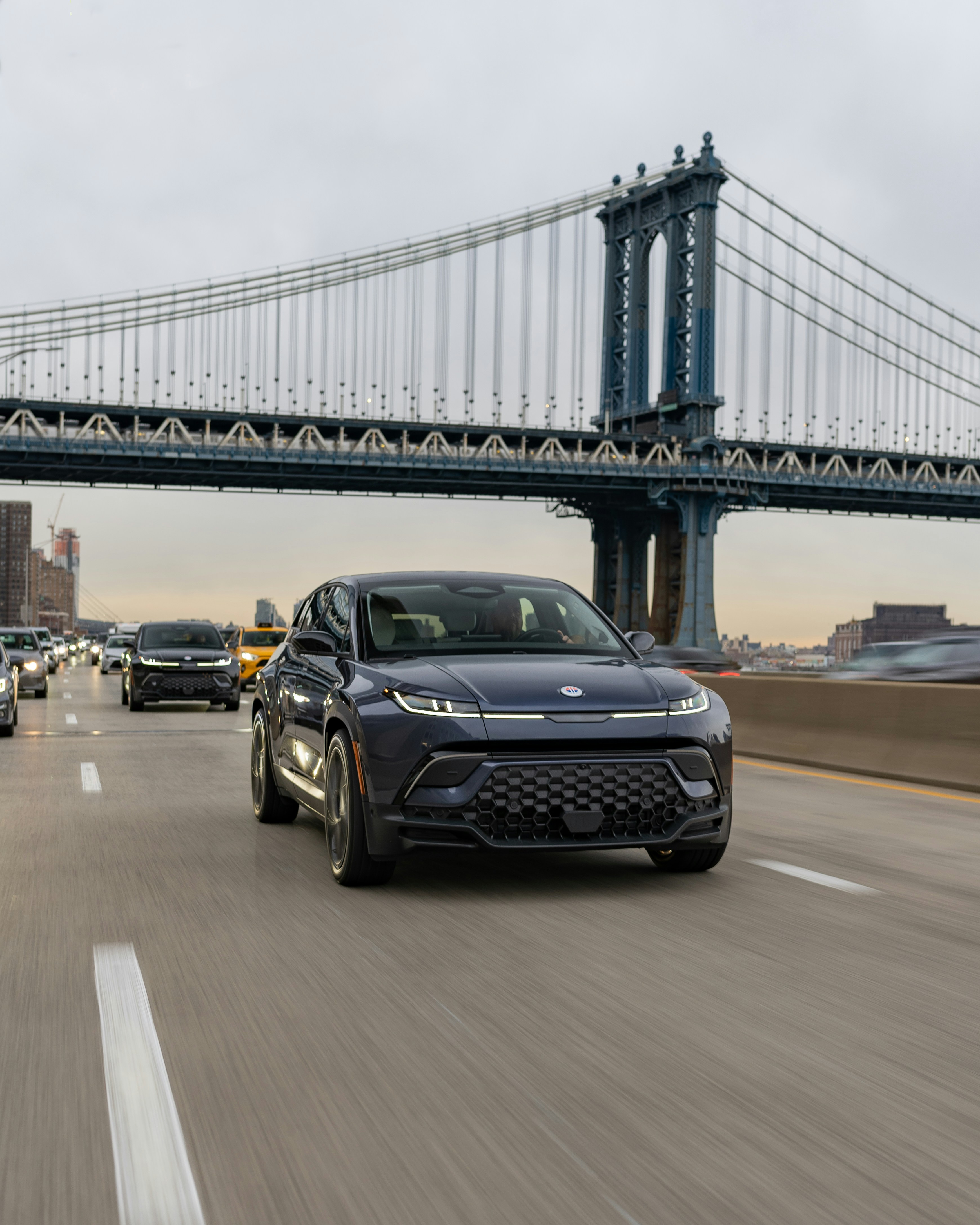 Urban Horizon: A Bold SUV Leads the Weekend Commute Under the Manhattan Bridge