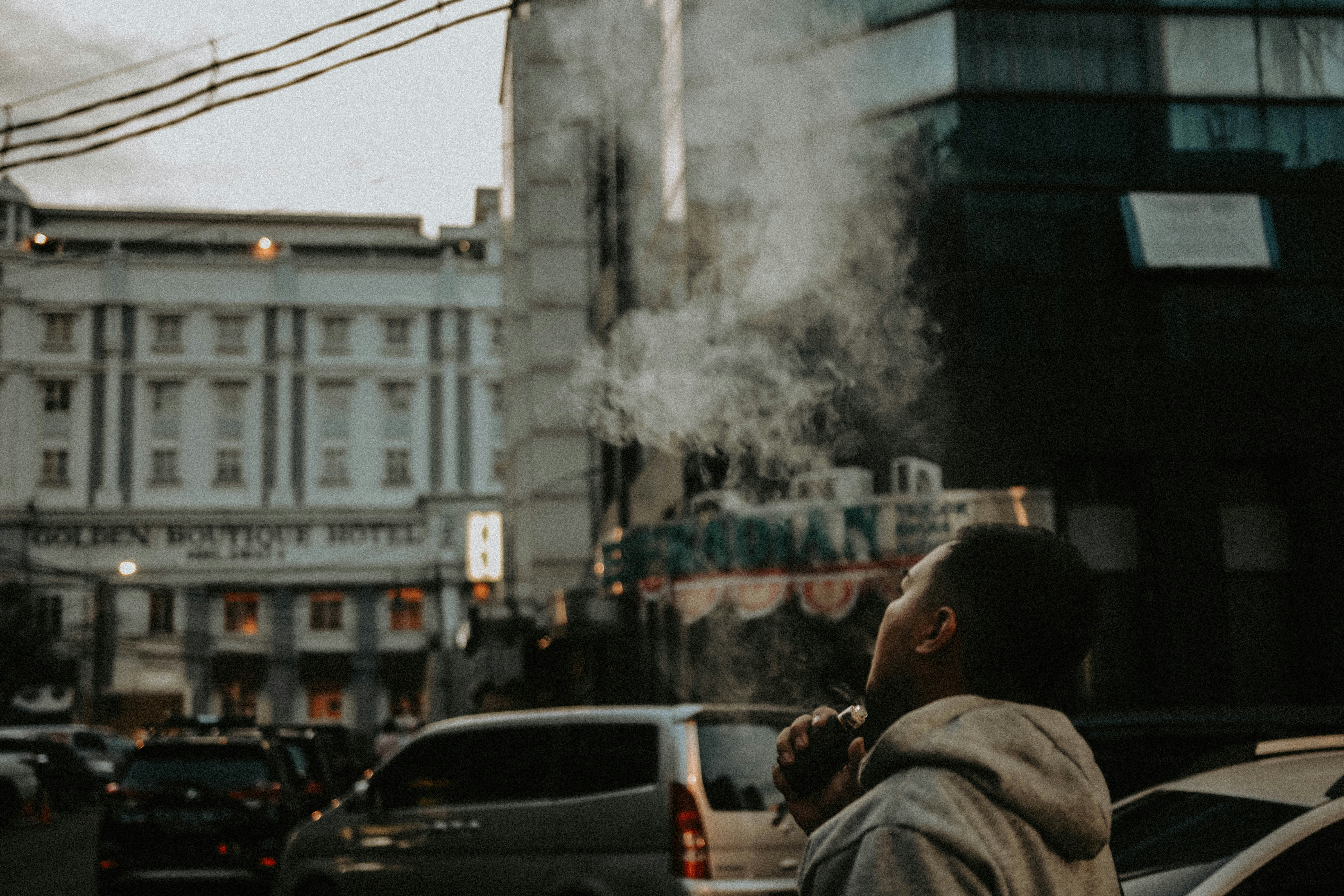 A man smoking a cigarette on a city street photo – Free Photo Image on ...