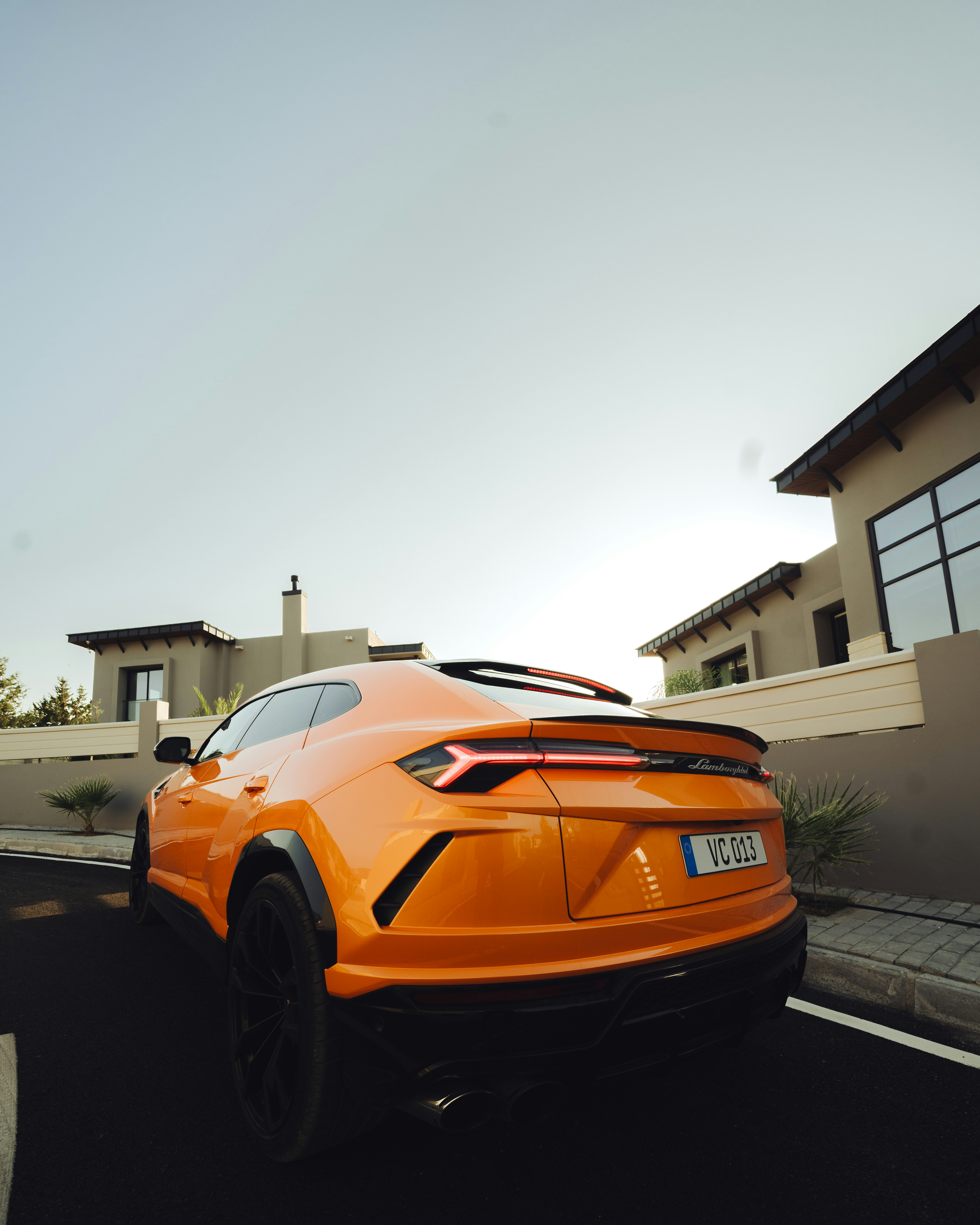 An orange sports car driving down a street photo – Free Creative ...