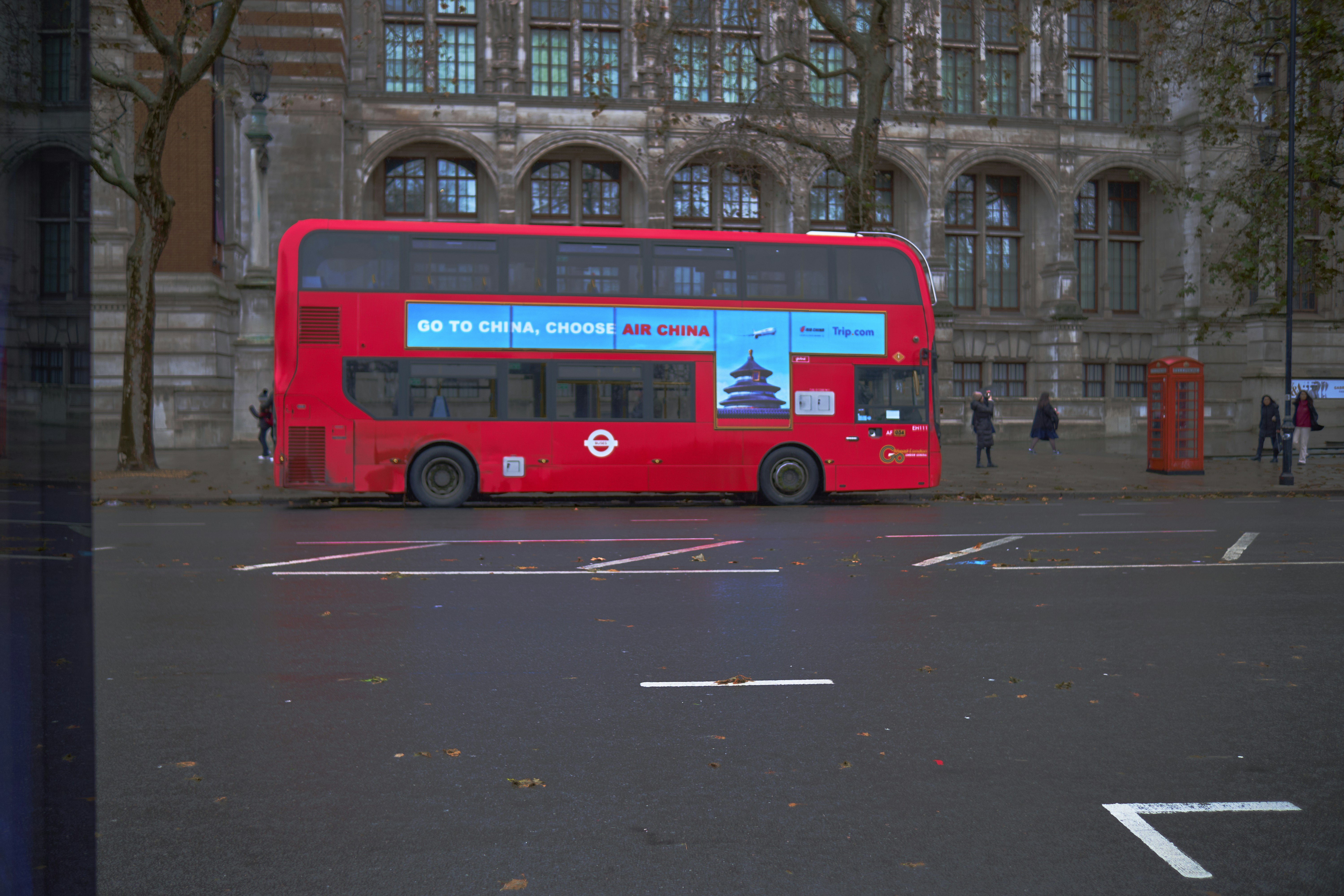 A red double decker bus parked in front of a building photo – Free Bus ...
