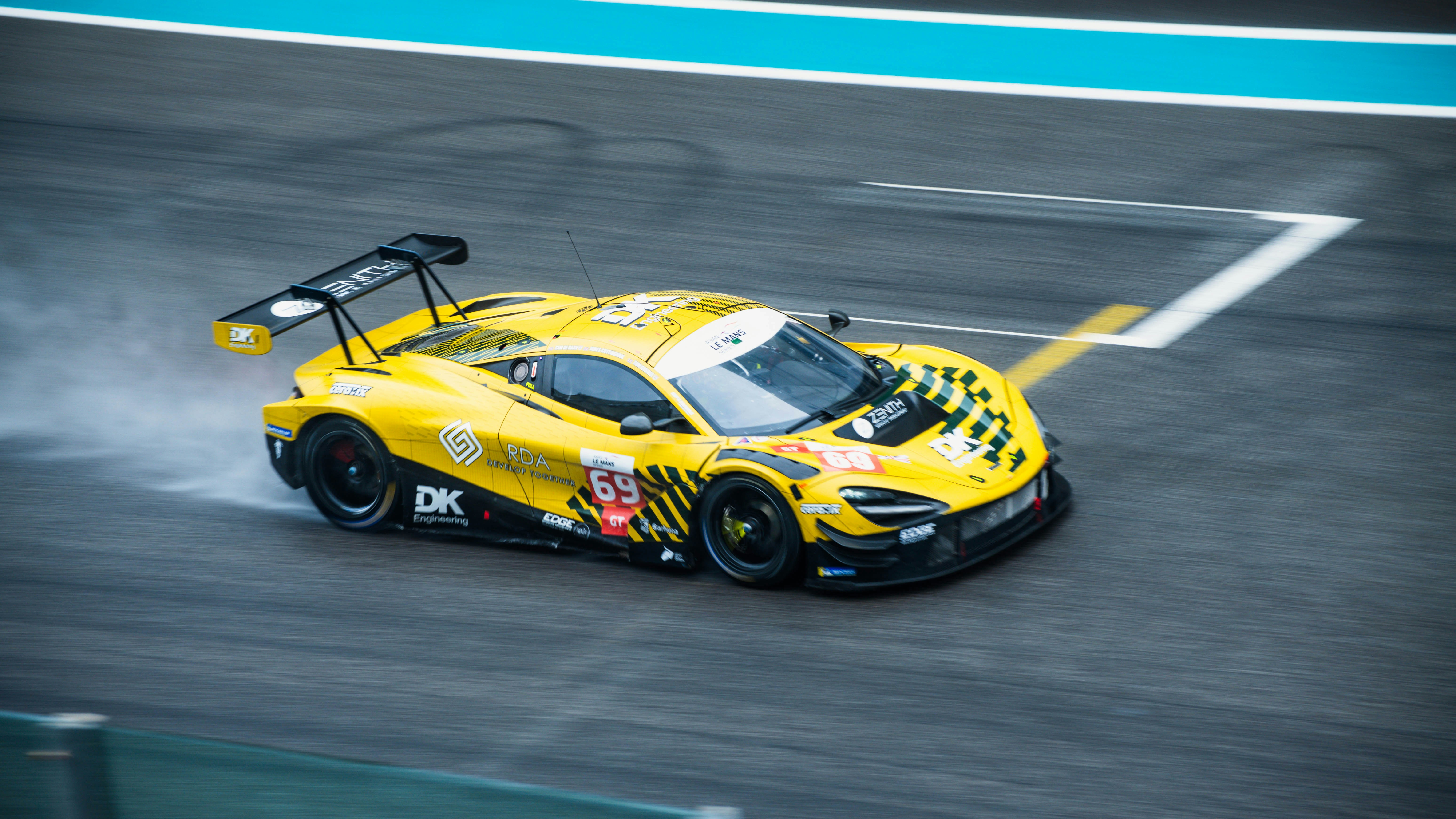 A yellow race car driving on a race track photo – Free Automobile Image ...