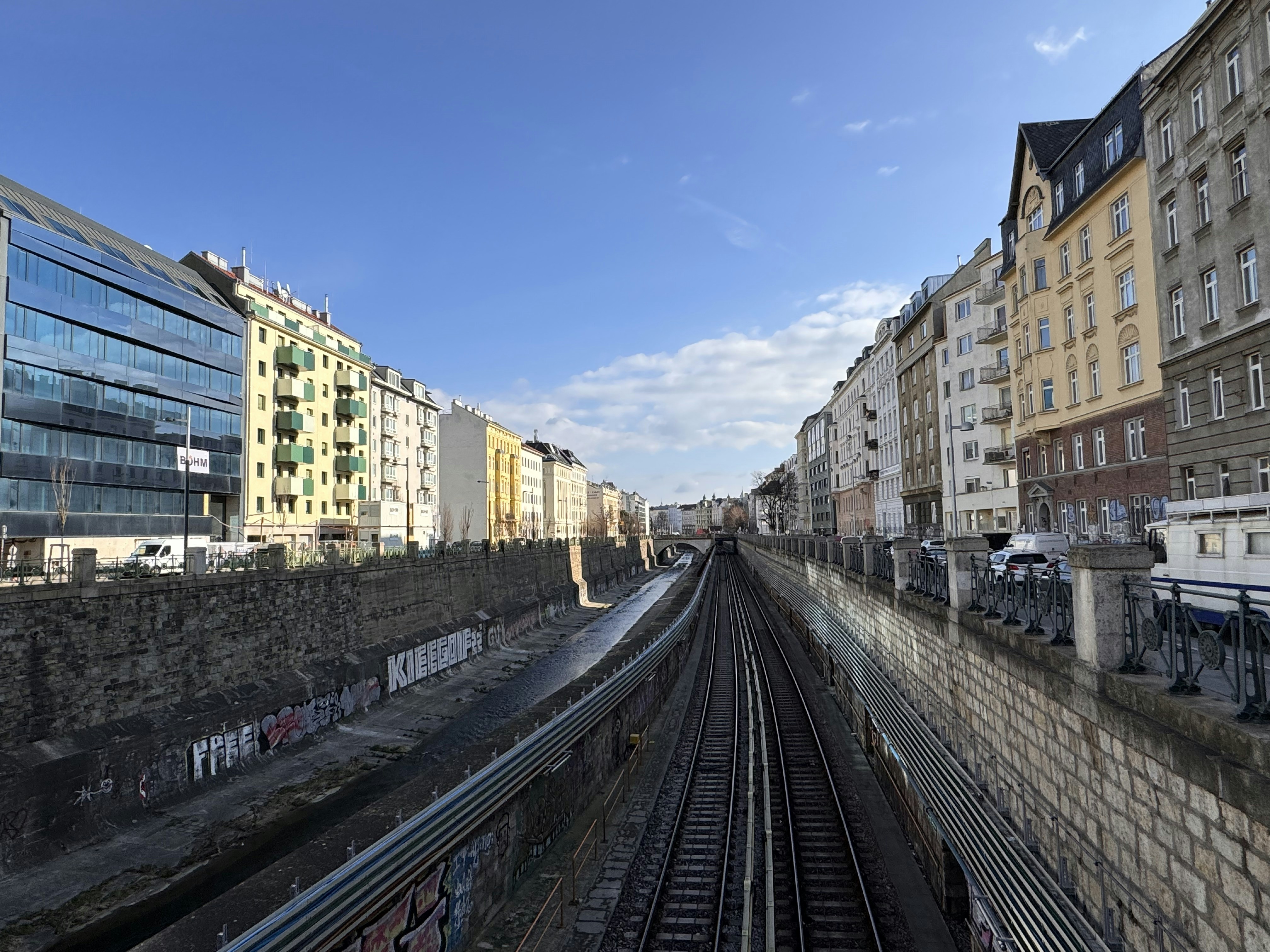 A train traveling down train tracks next to tall buildings photo – Free ...