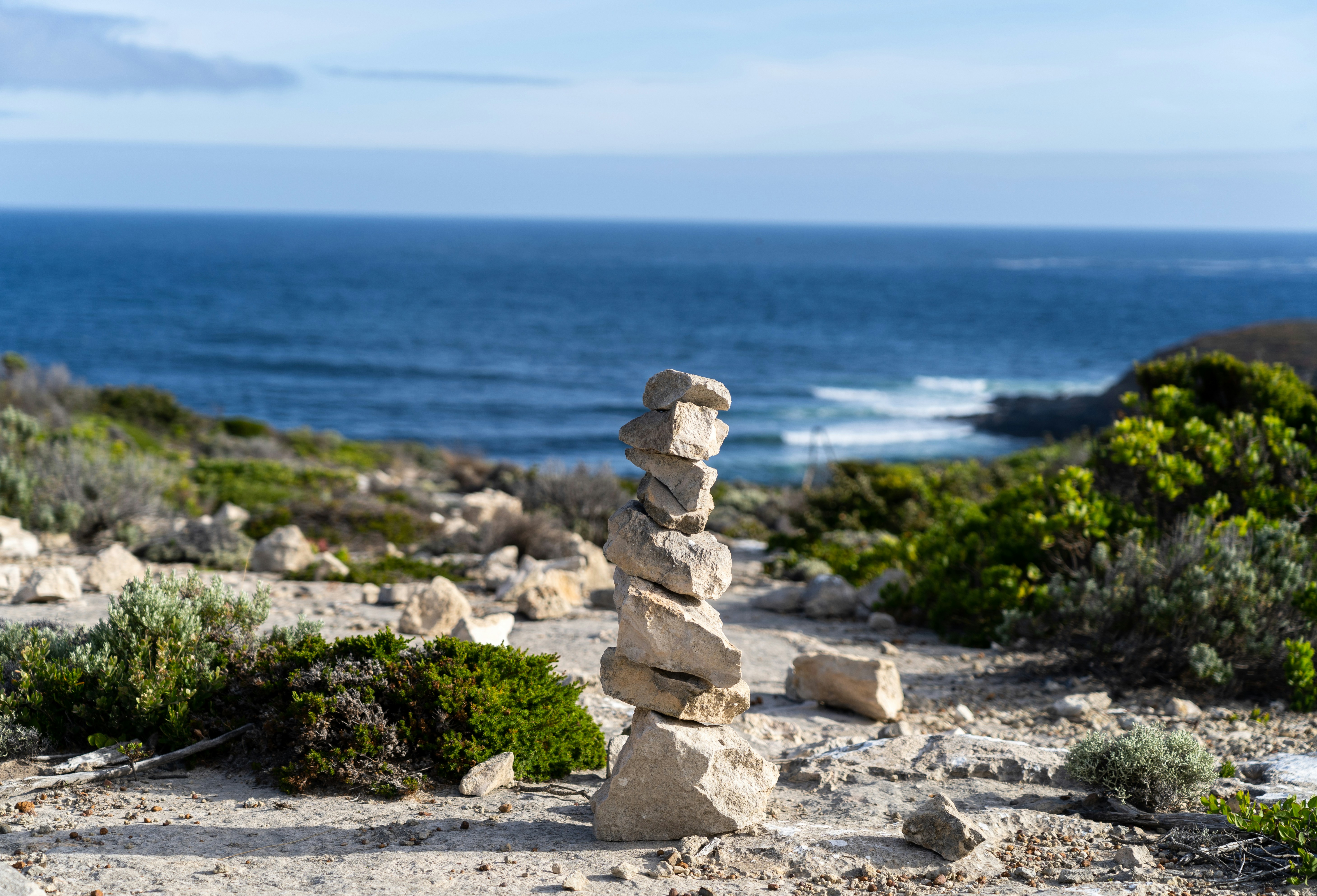 A stack of rocks sitting on top of a sandy beach photo – Free Blue ...