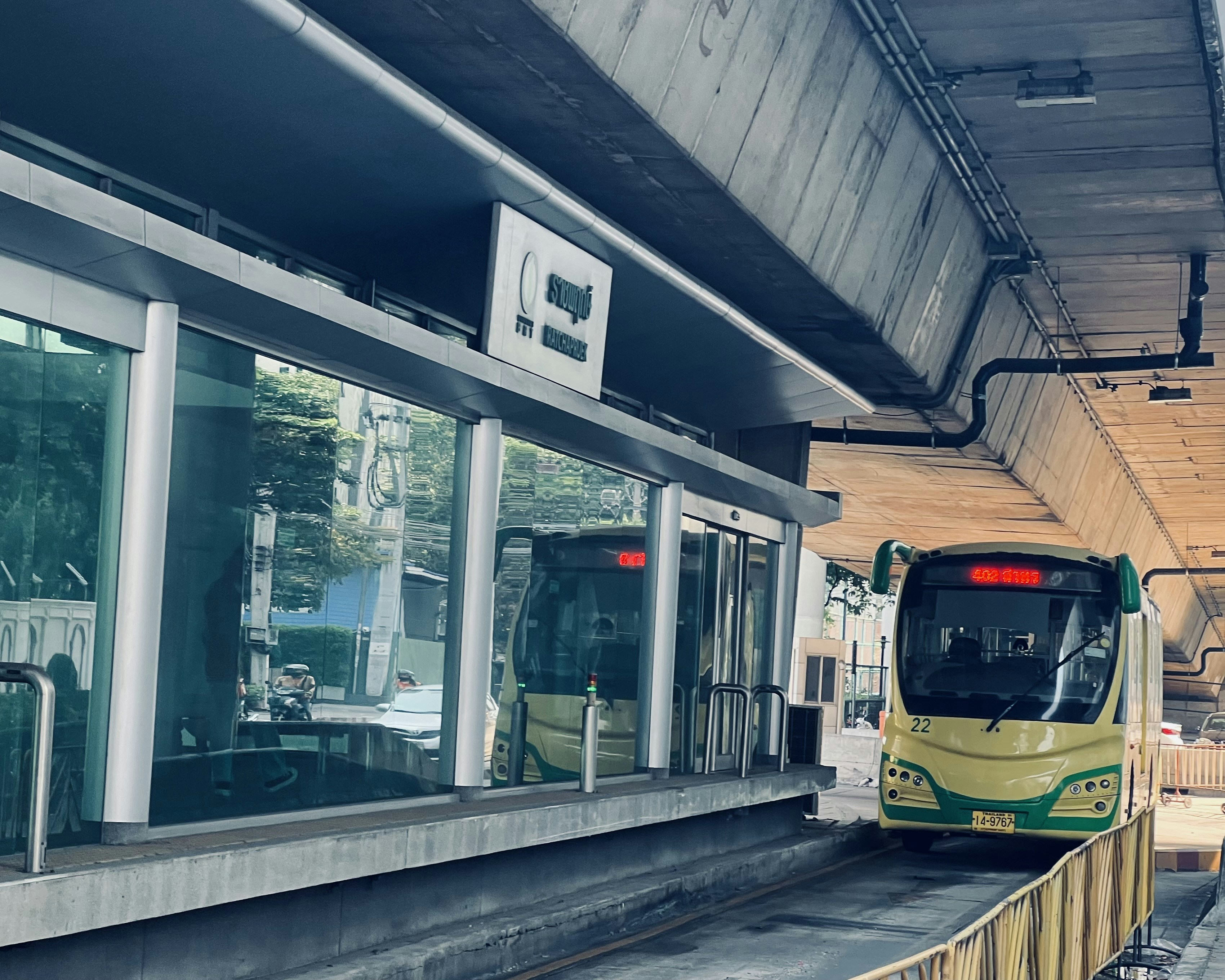 A yellow and green bus parked at a bus stop photo – Free Bus Image on ...