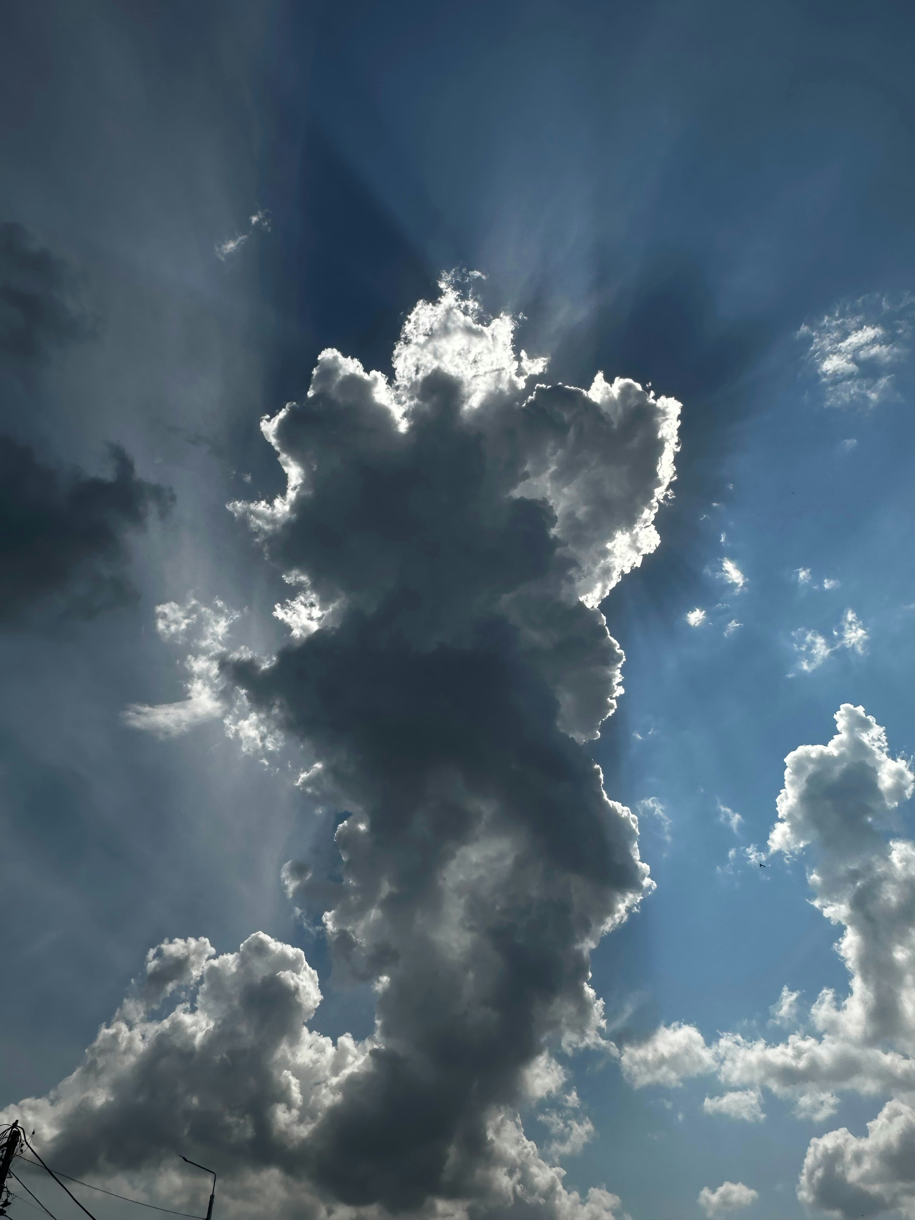 A very tall cloud in the sky with a bright sun behind it photo – Free ...