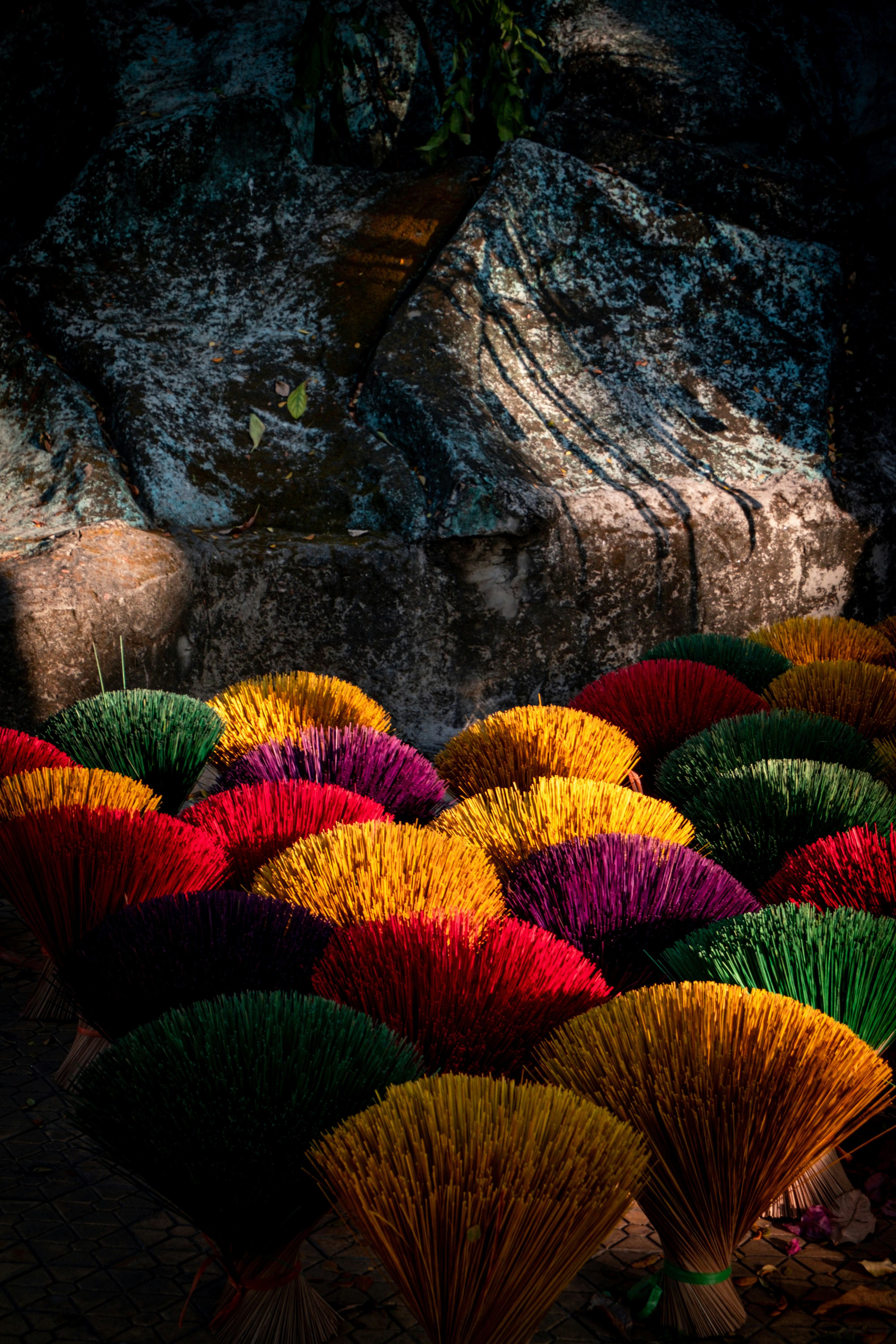 Sunlit Cluster of Colorful Straw Fans by Weathered Granite