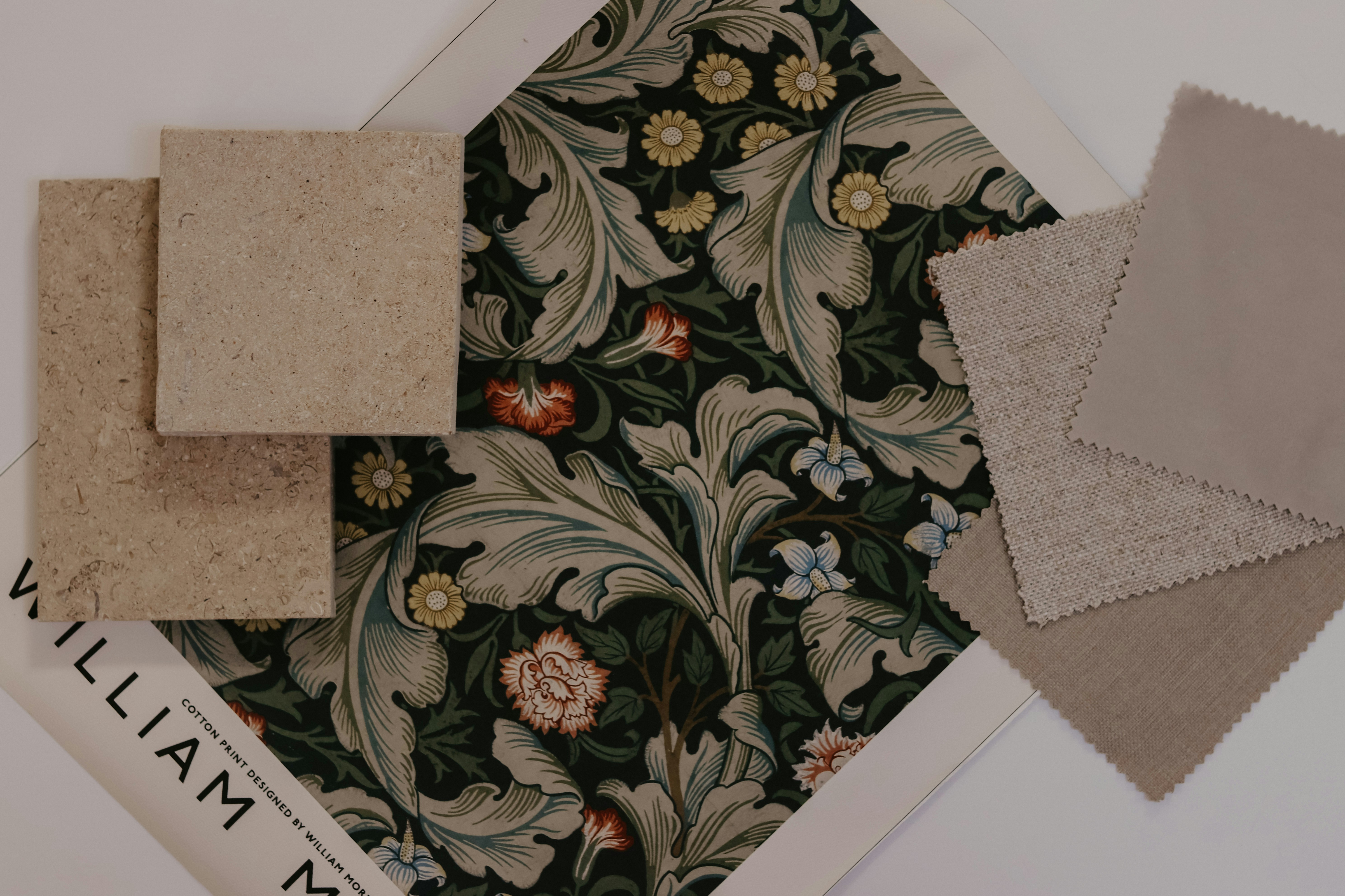 Floral patterned fabric surrounded by neutral textile swatches on a white surface.
