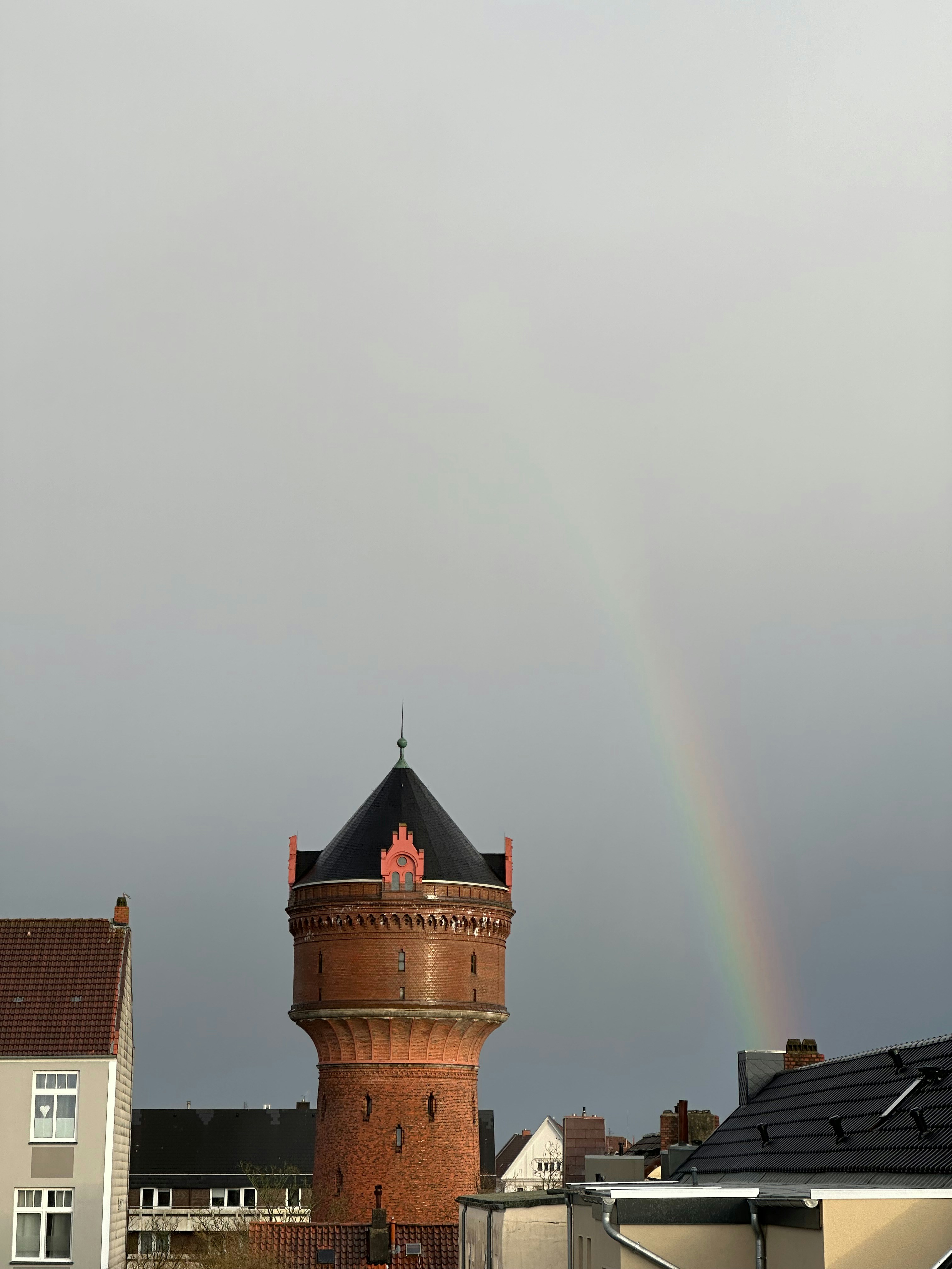 Rainbow Arc Over Red Brick Water Tower: Rooftop Calm