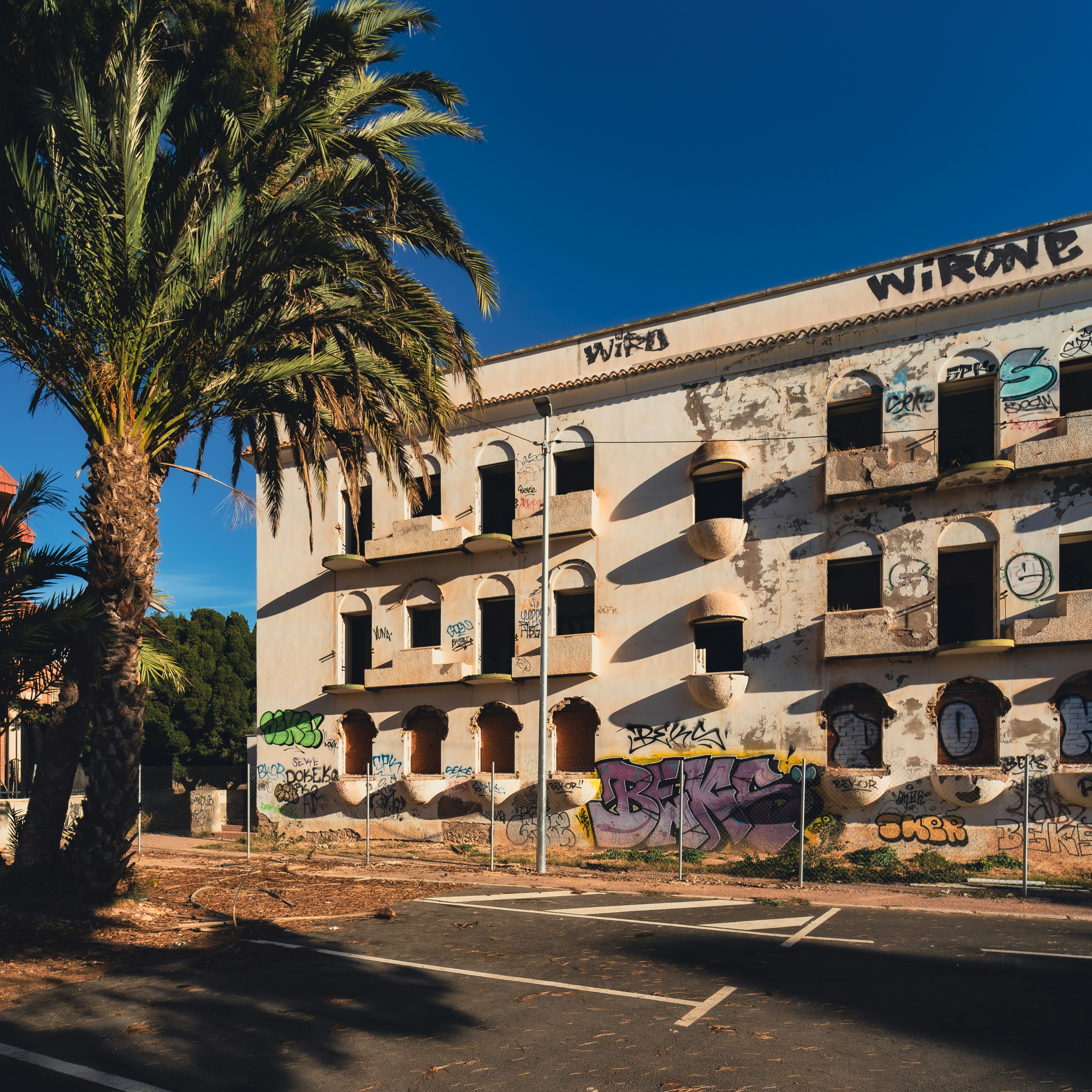 Sunlit Graffiti-Flecked Warehouse: A Deserted Corner of Echoing Arches