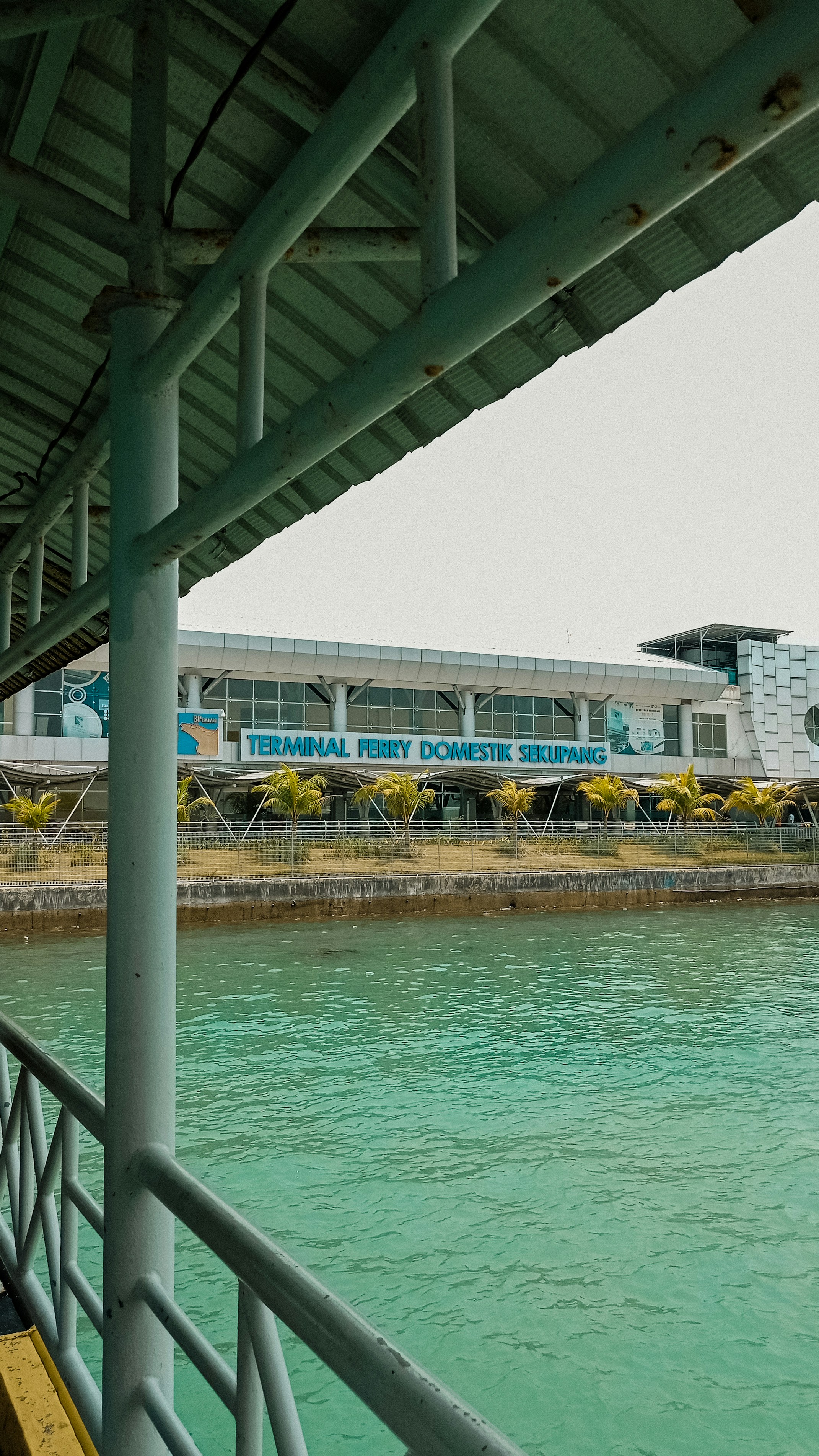 A train traveling down tracks next to a body of water photo – Free ...
